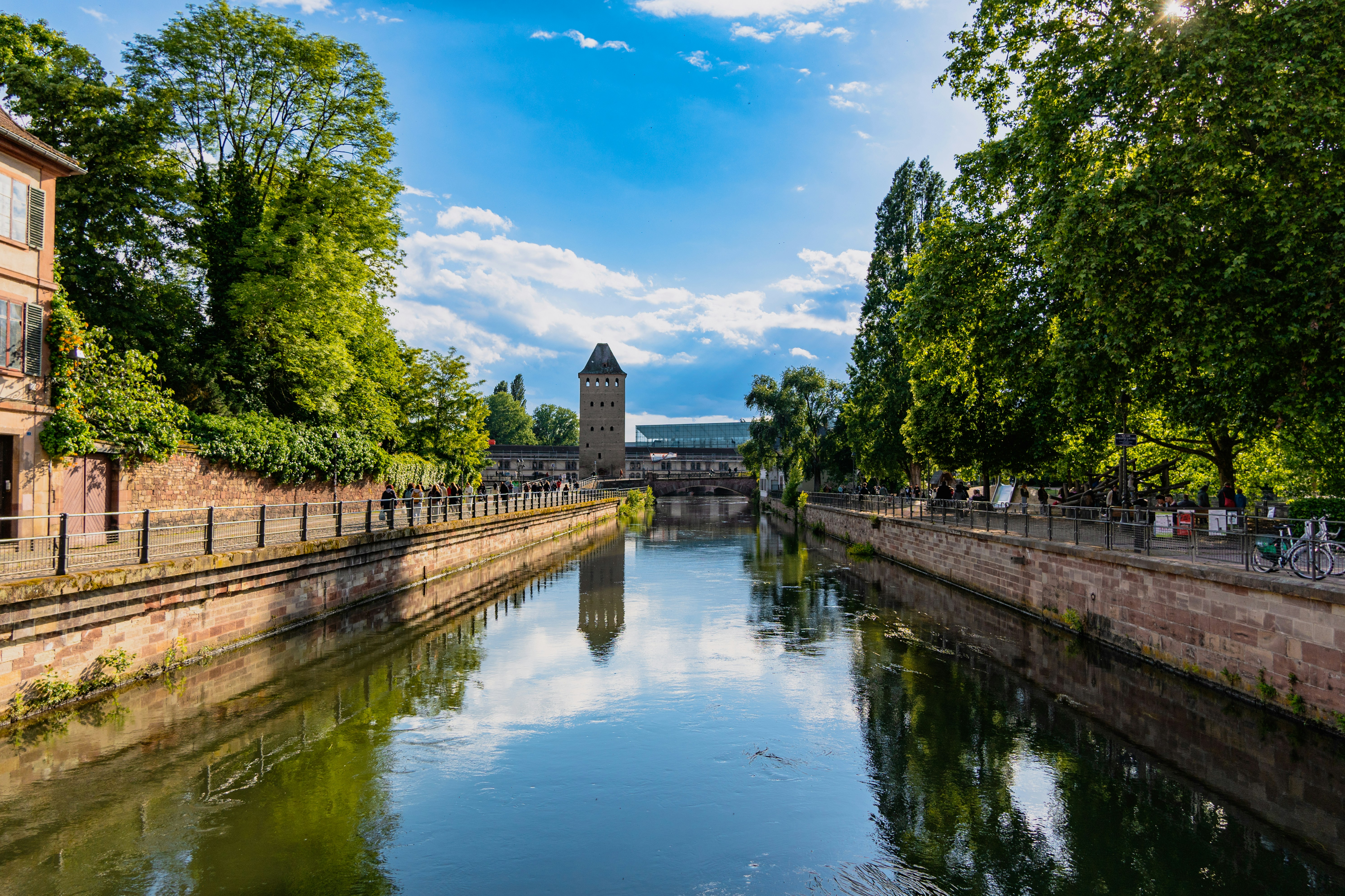 Toward the Tower: A Reflective Canal Between Brick Walls