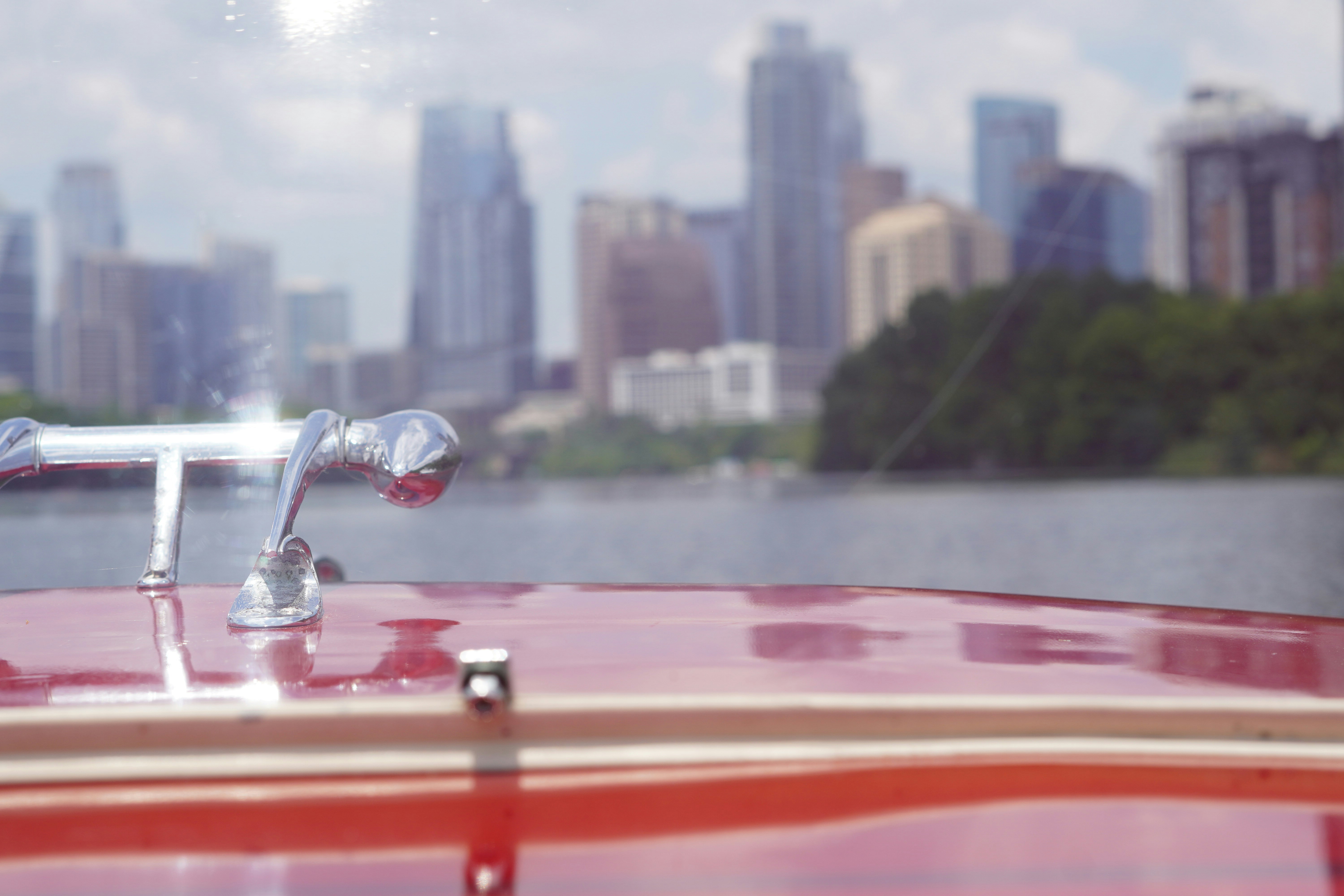 Chrome Glint on a Red Bow: Cityscape Reflections from the Deck