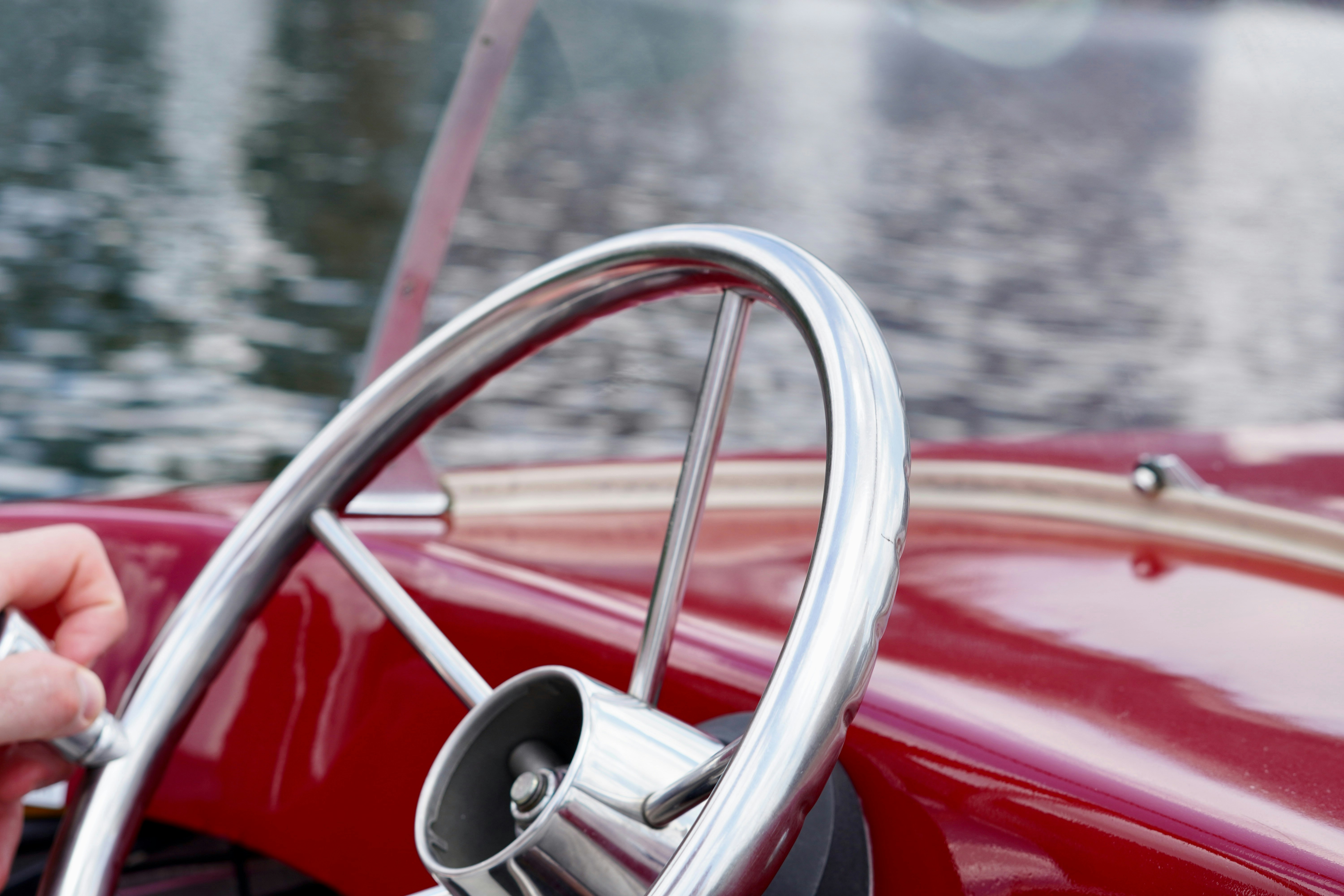 Steering Into Nostalgia: Close-Up of a Classic Red Boat Helm