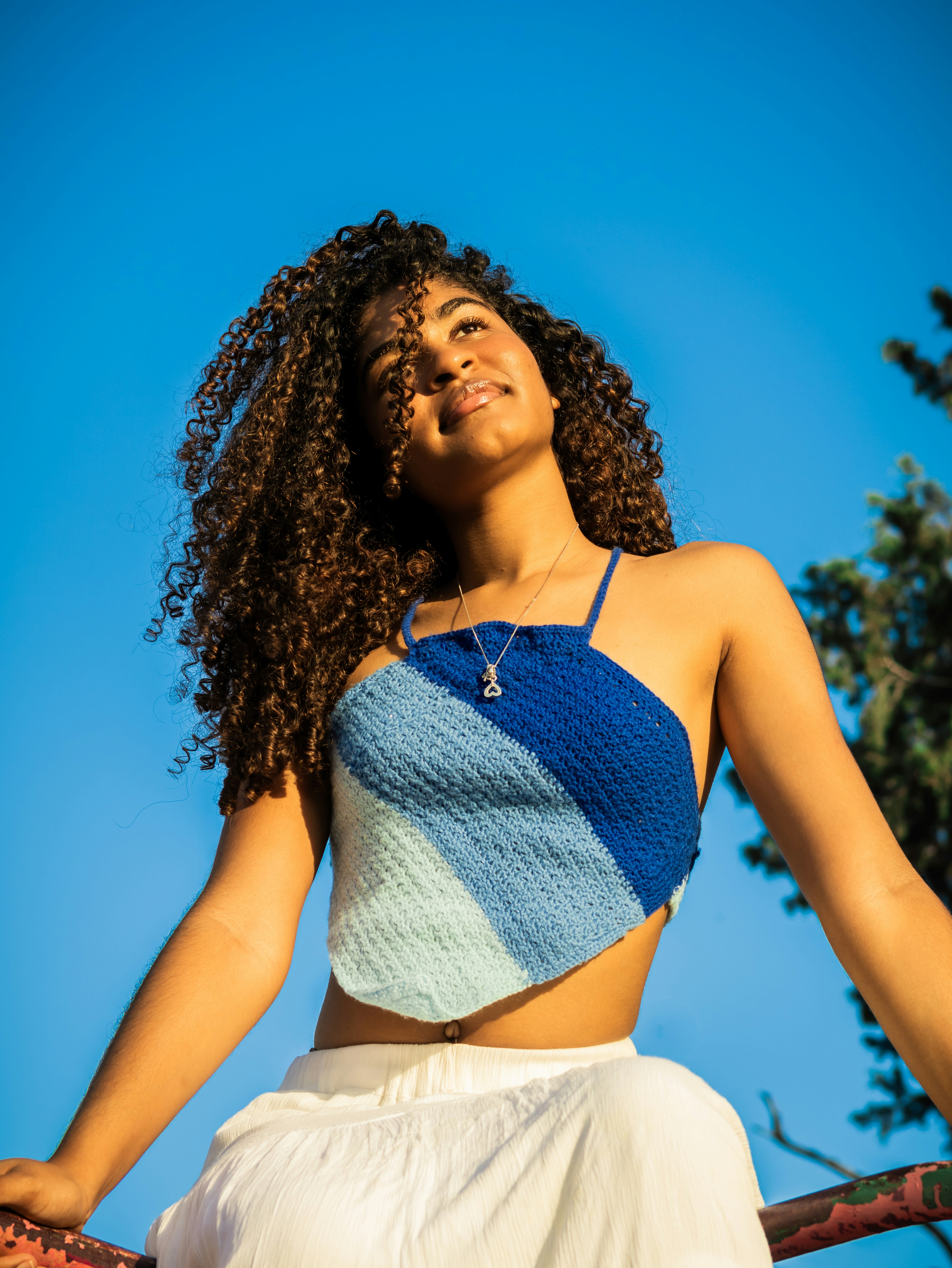 Sunlit Confidence: A Cropped Portrait in Blue Kilim Knit