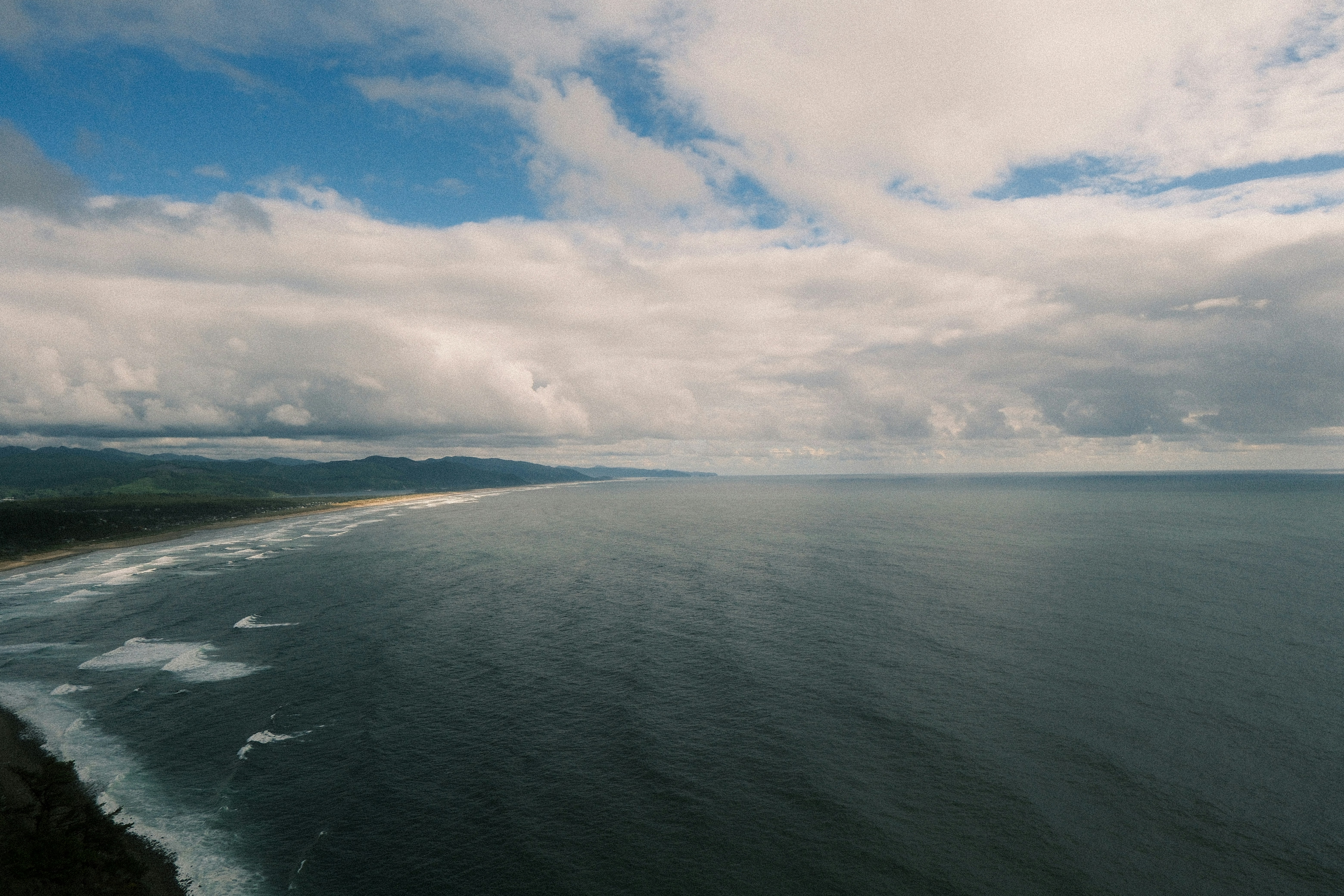Coastline Unfolds Under Wide Sky