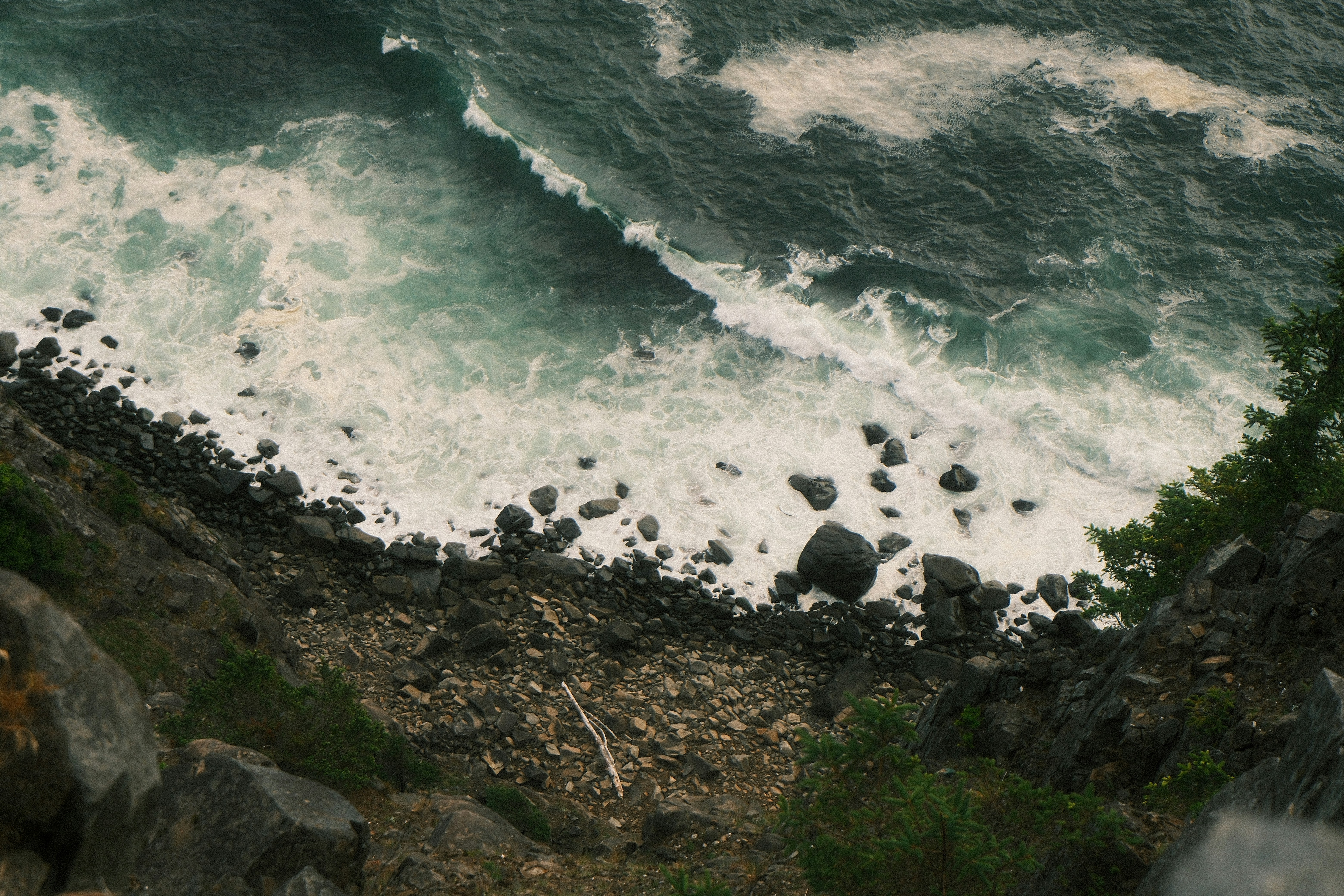 Brink Between Foam and Rock: A Cliffside View of Turbulent Surf