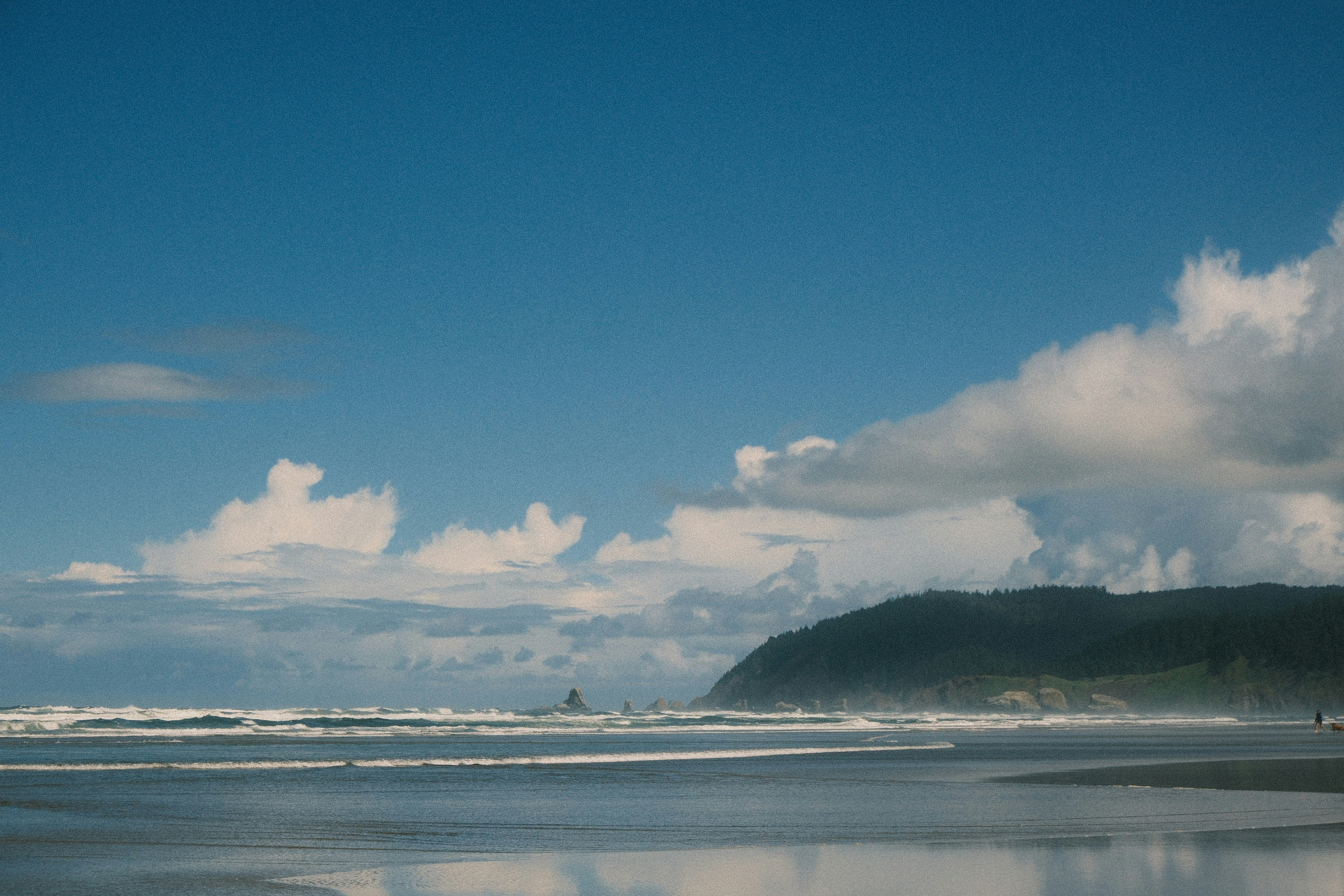 Coastal Horizon: Quiet Beach Under a Looming Headland