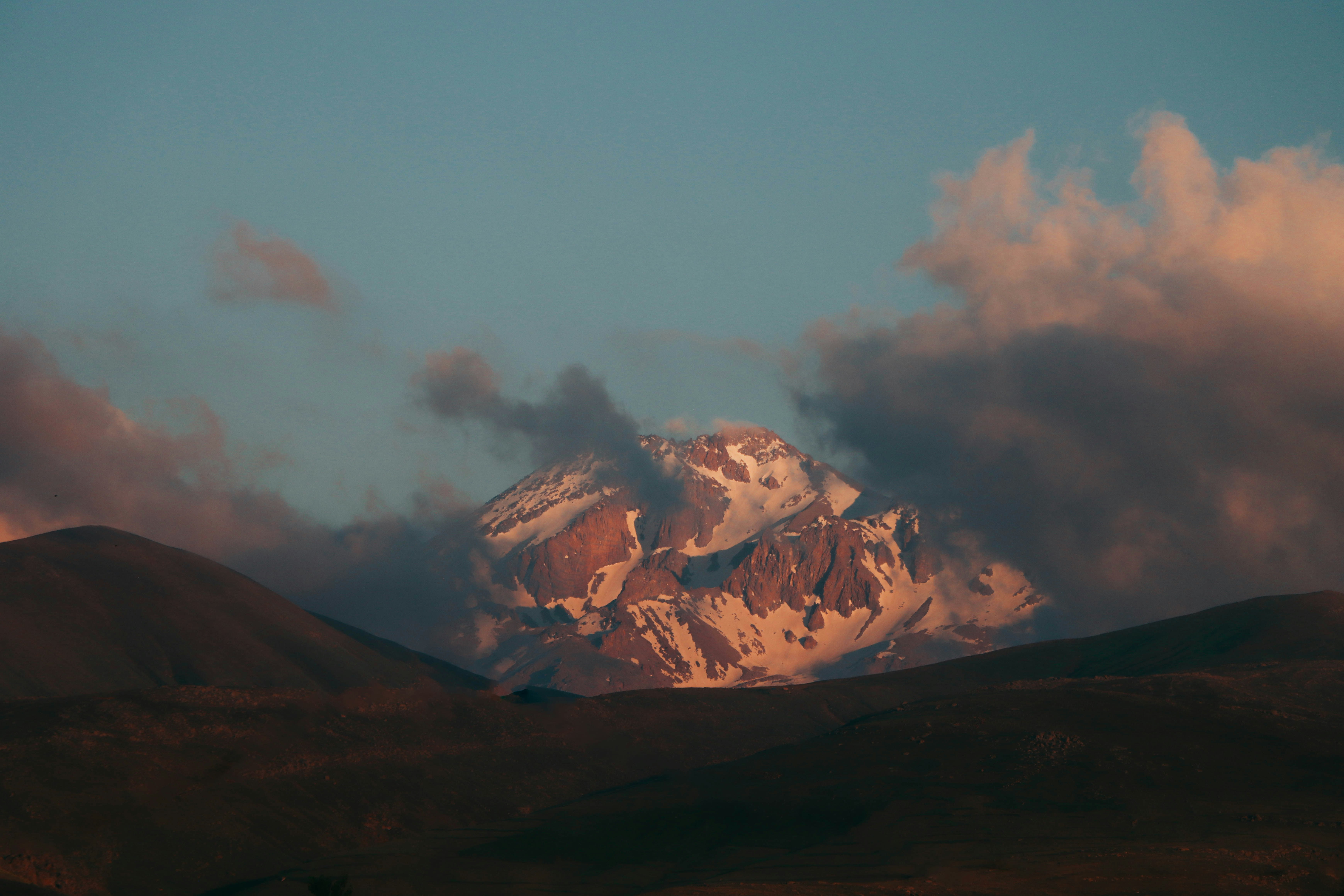Snow-capped Peak Piercing a Veil of Dusk Clouds
