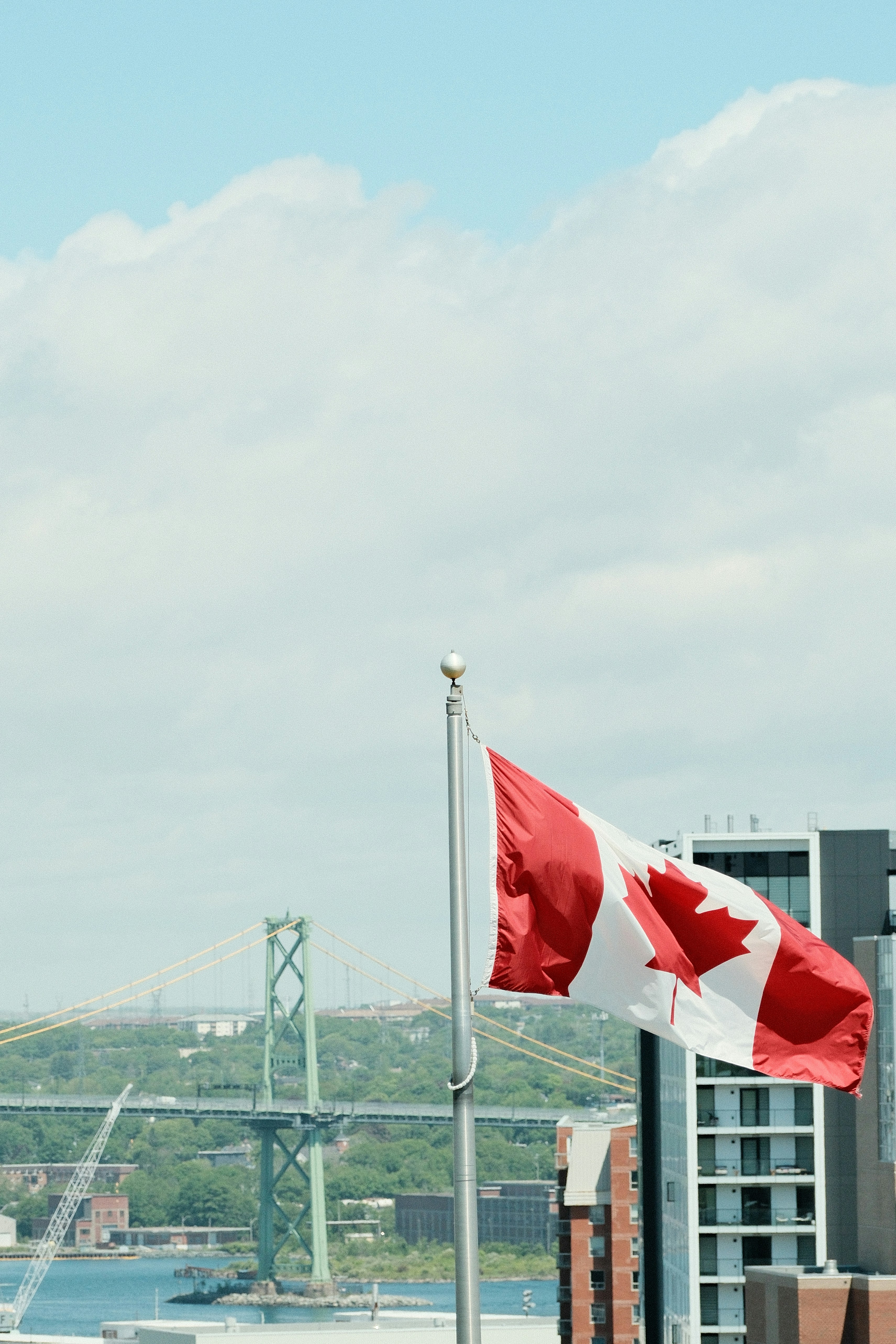 Flag in the wind over a cityscape bridge