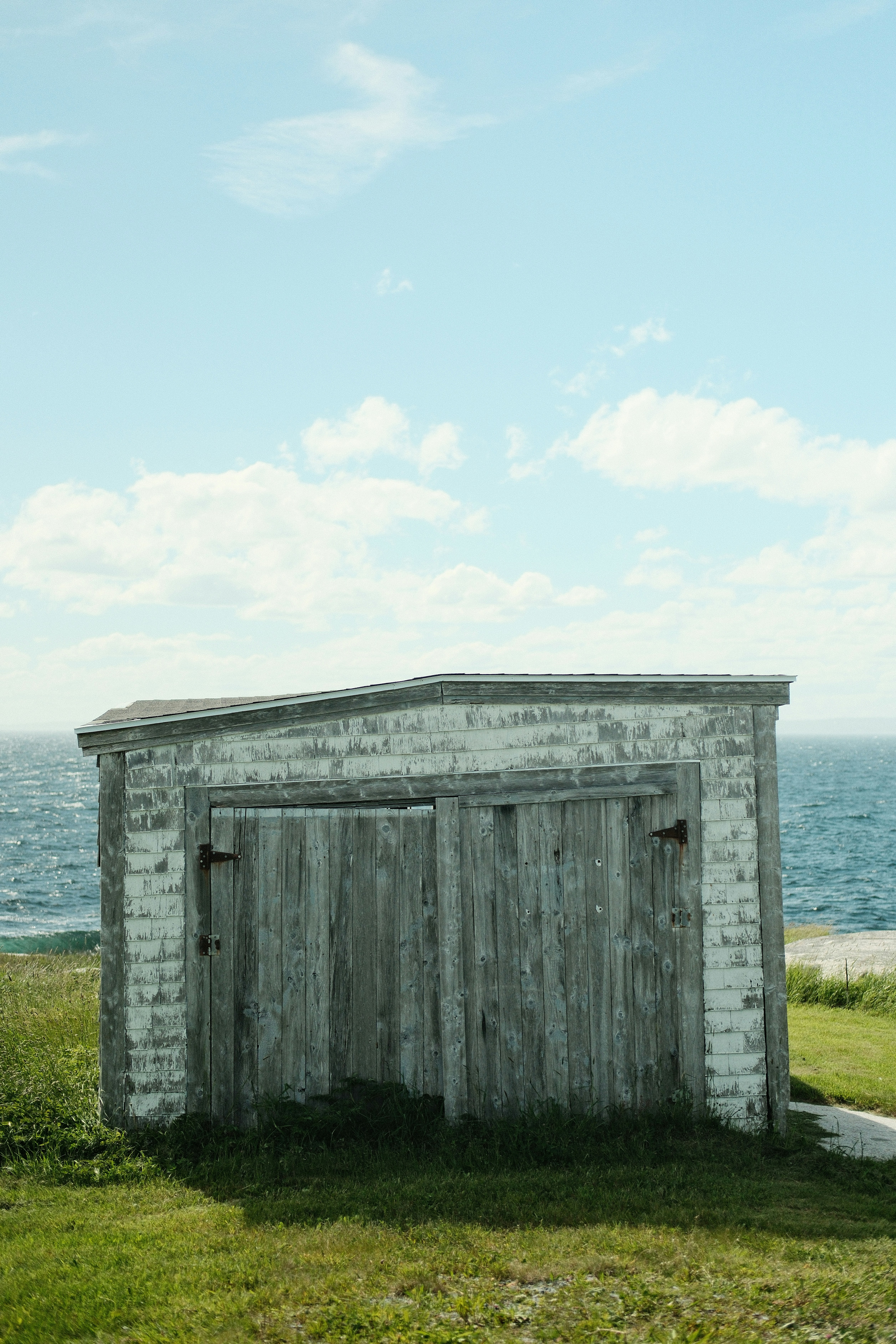 Weathered boathouse at the edge of blue horizons