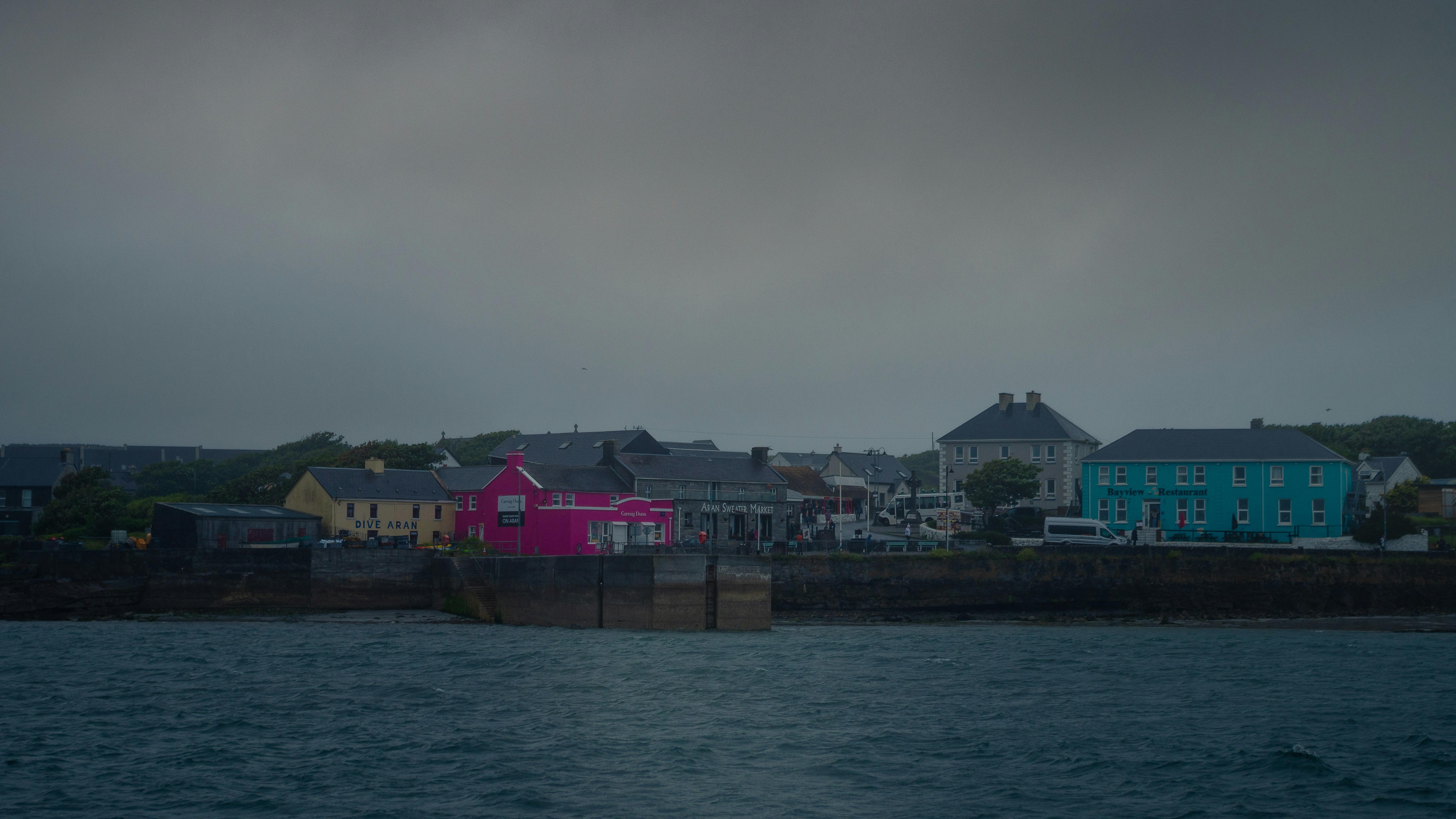 Colorful Row of Coastal Houses Framed by Stone Wharf