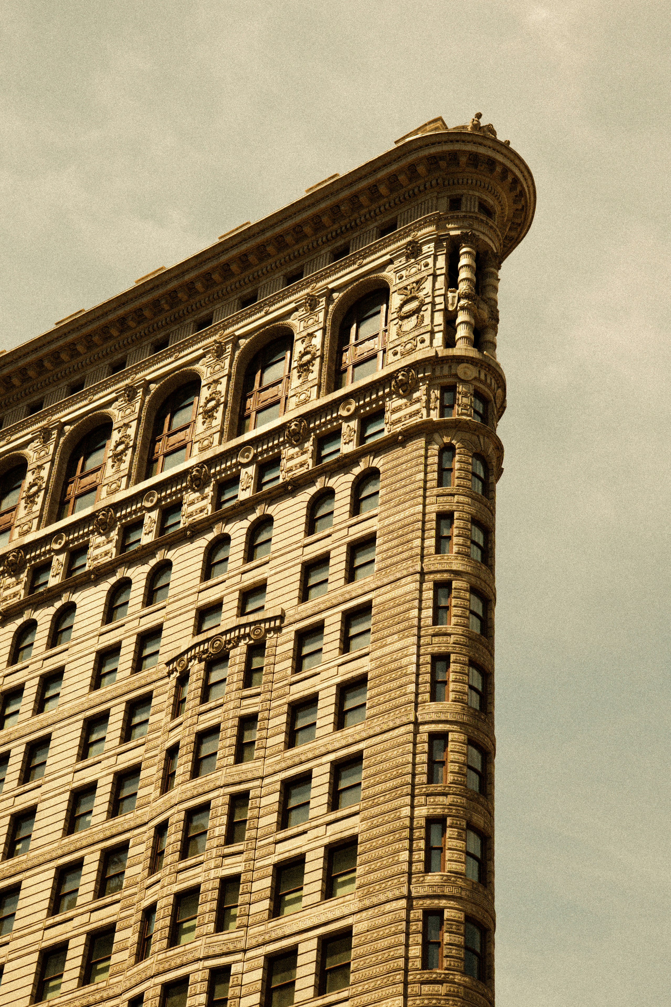 Cornerstone of the City: Adorned Façade Rises at the Edge of the Sky