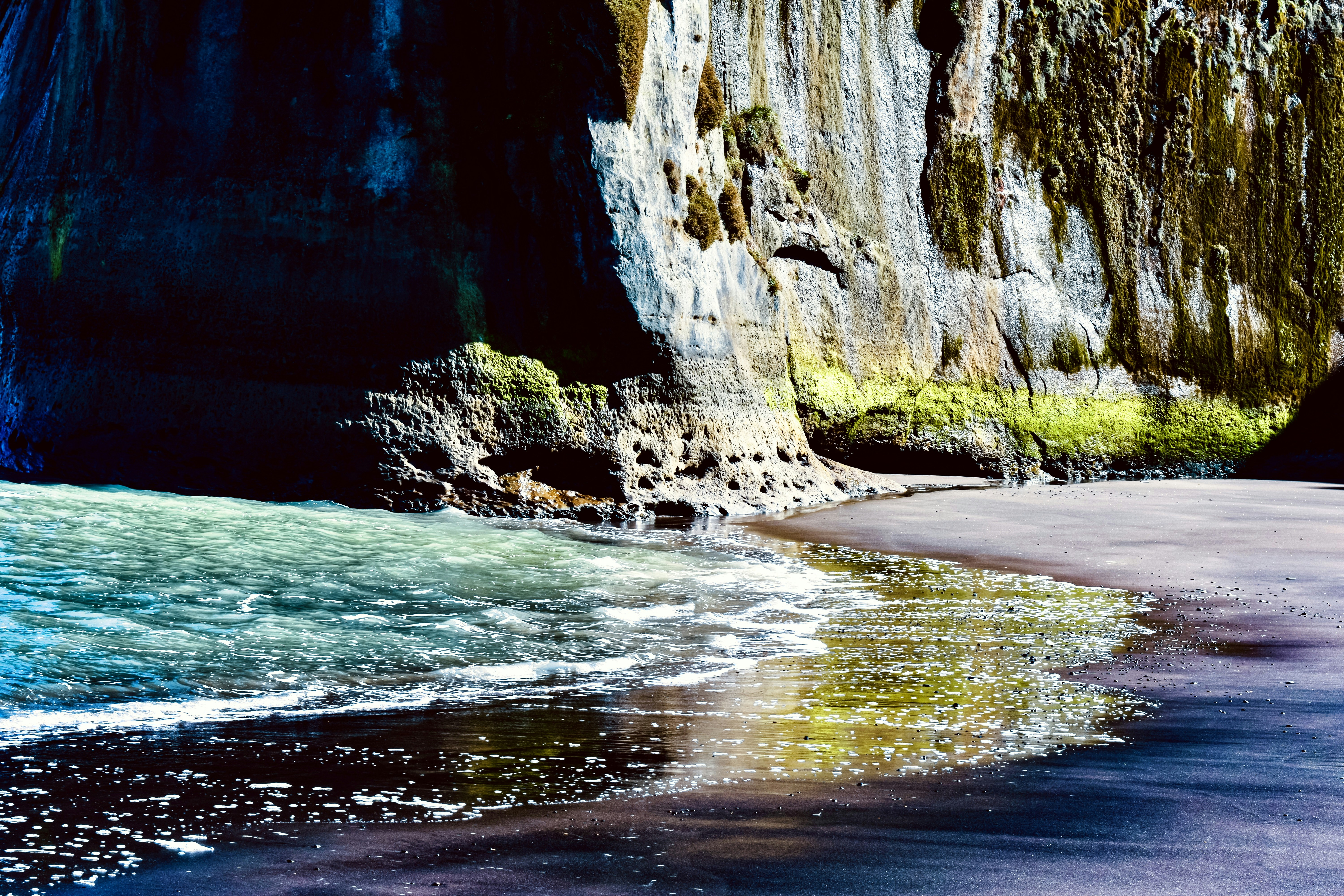 Sunlit Cove: Emergence of Teal Waves against Cliffside Shore
