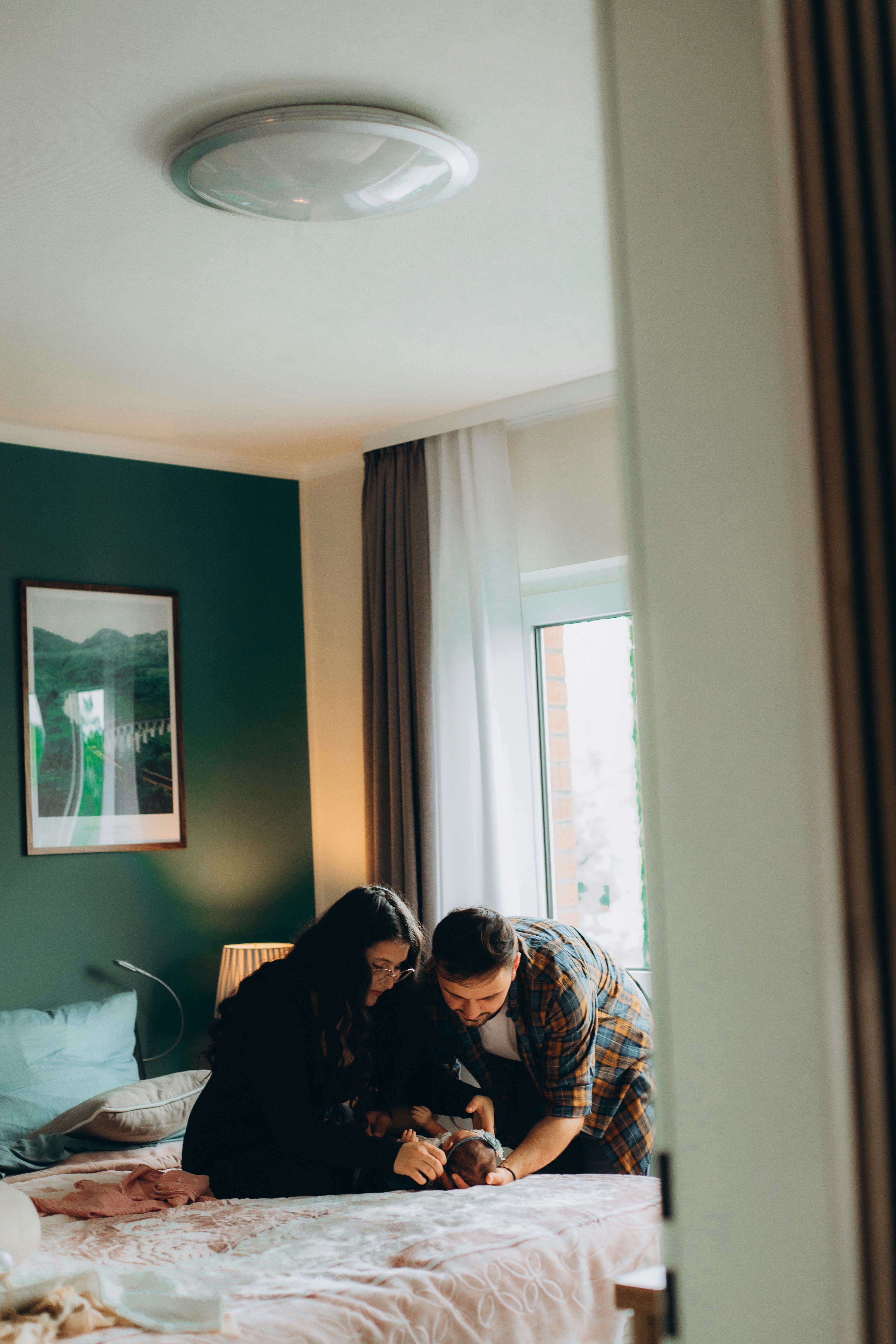 Family Moment on a Cozy Morning: Two Adults and a Baby in Soft Light
