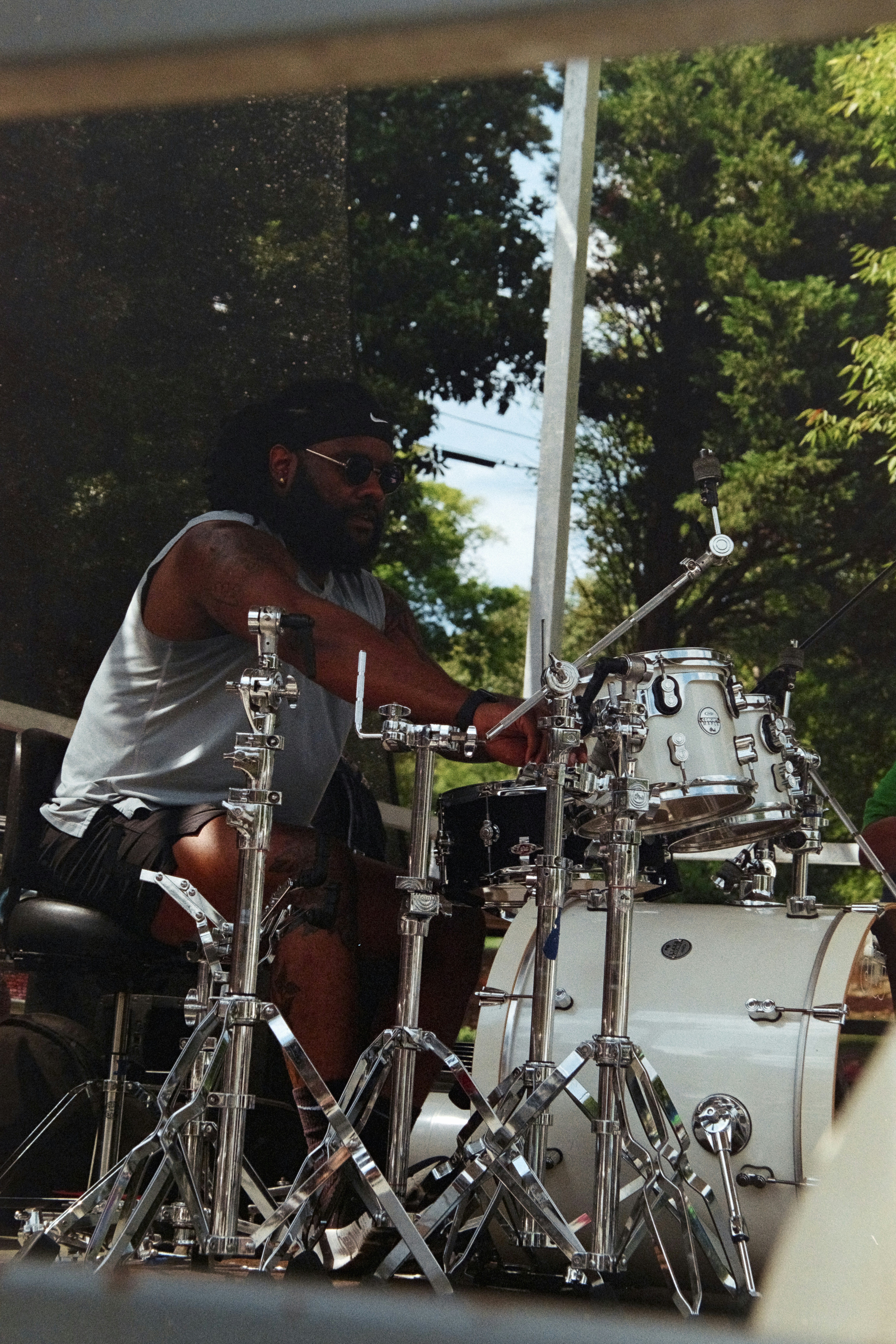 Drummer in Shade: Focused Beats beneath the Audience of Trees