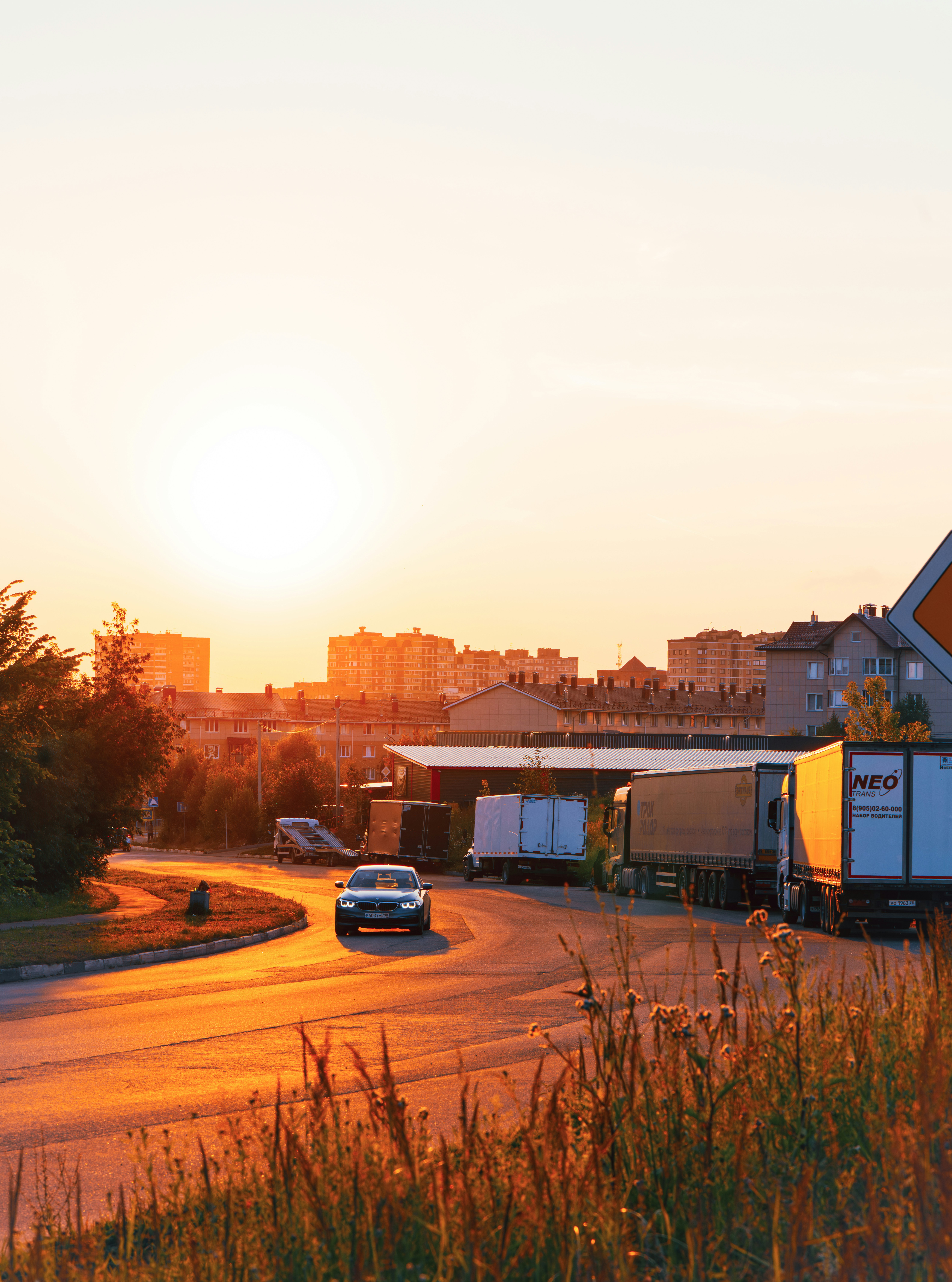 Sunlit Queue: Trucks and Towering Light