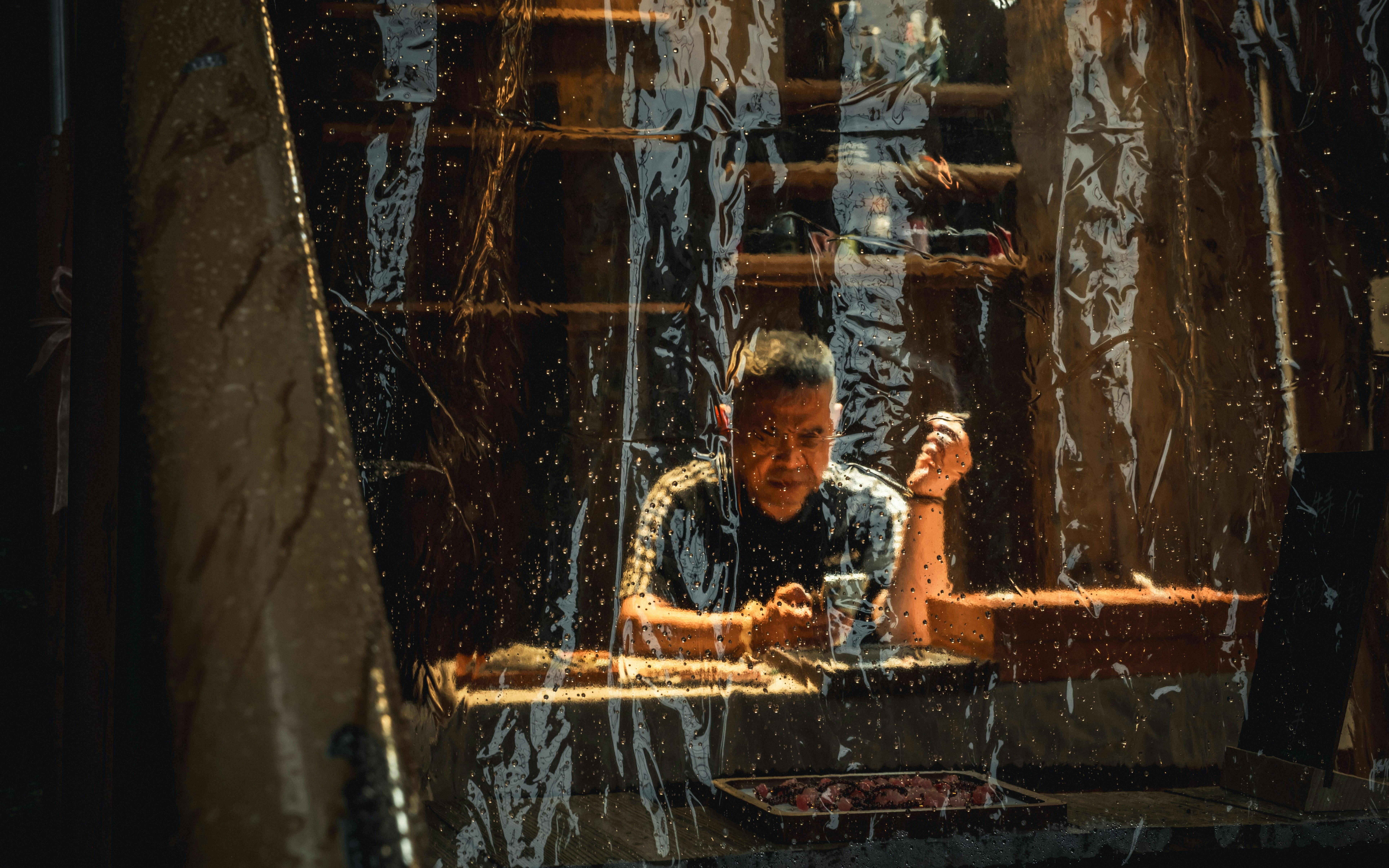 Through the Plastic Veil: A Quiet Moment Behind Carved Curtains