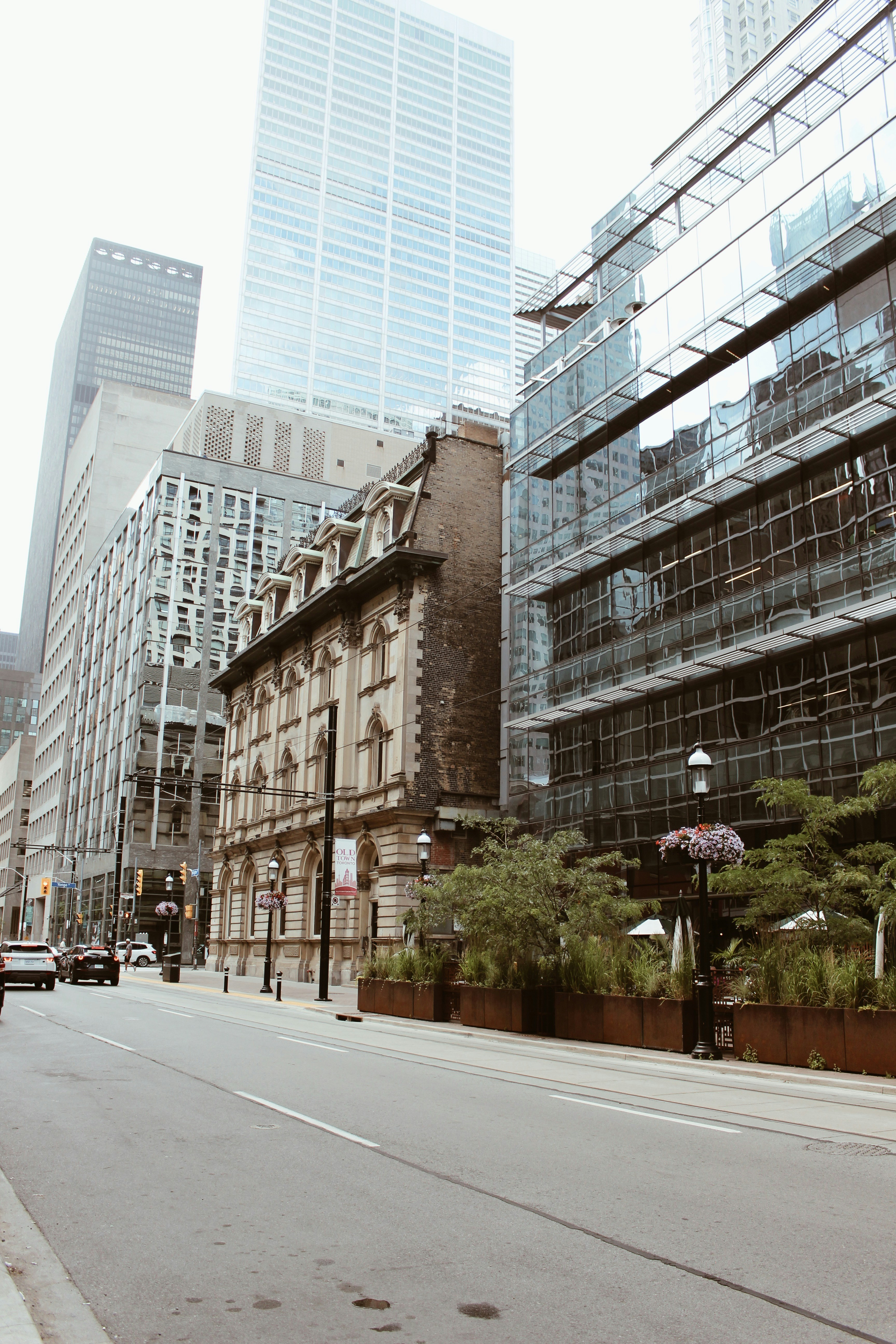 Urban Facades: A Quiet Corridor Between Historic Brick and Glass Skyscrapers