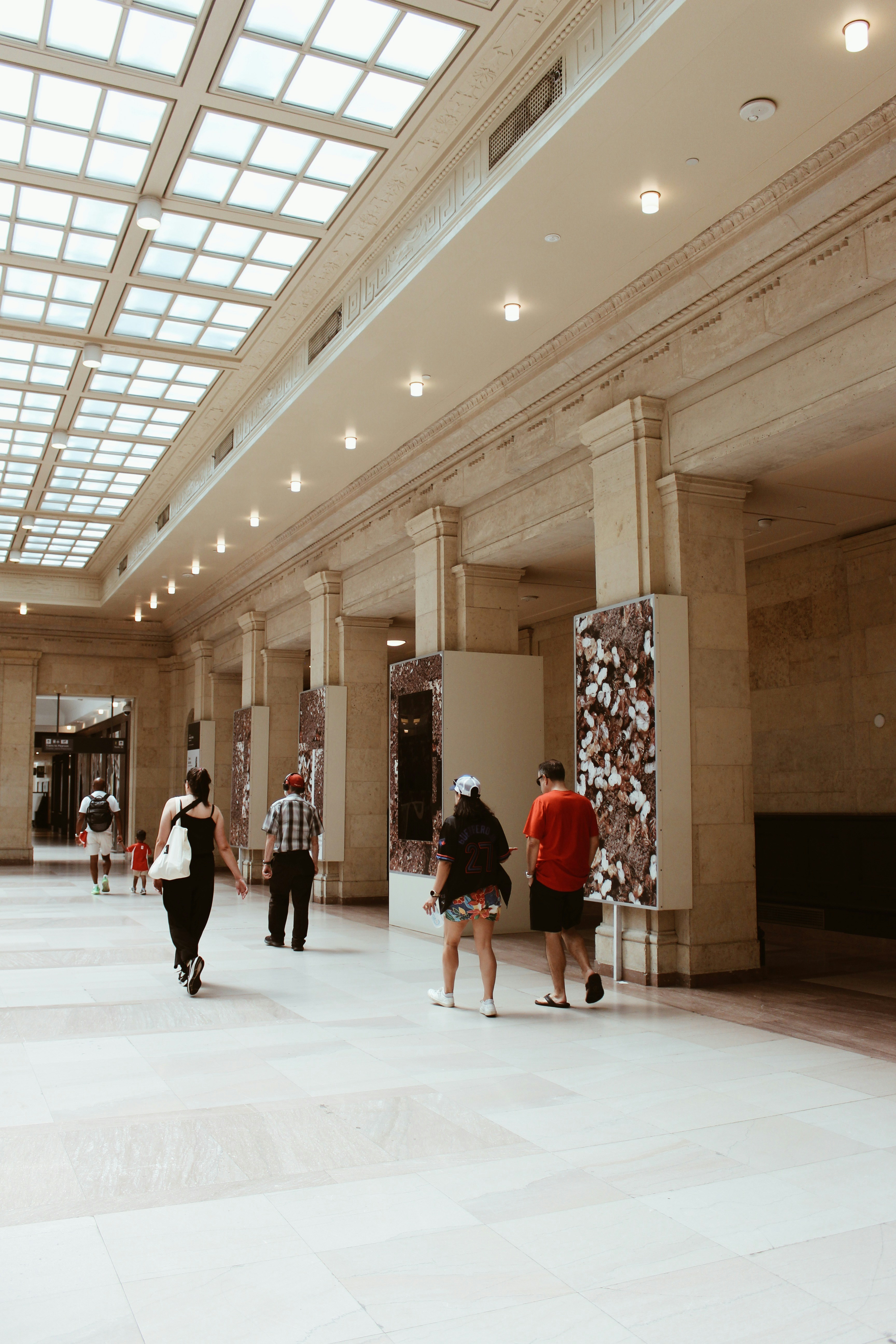 Museum Atrium Stroll: Visitors meander beneath skylit arches
