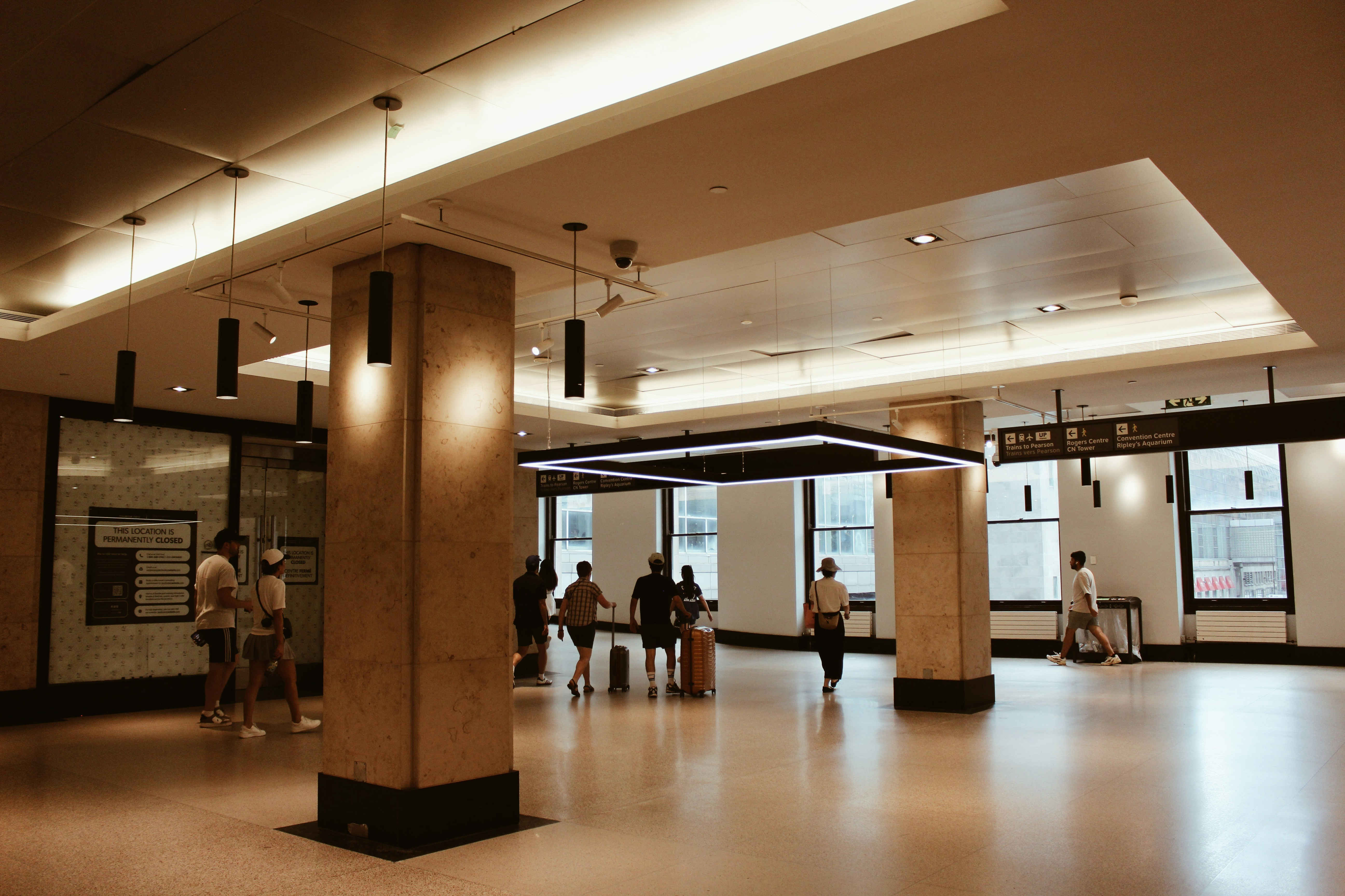 Quiet Transit: People Gather in a Sunlit Underground Hall