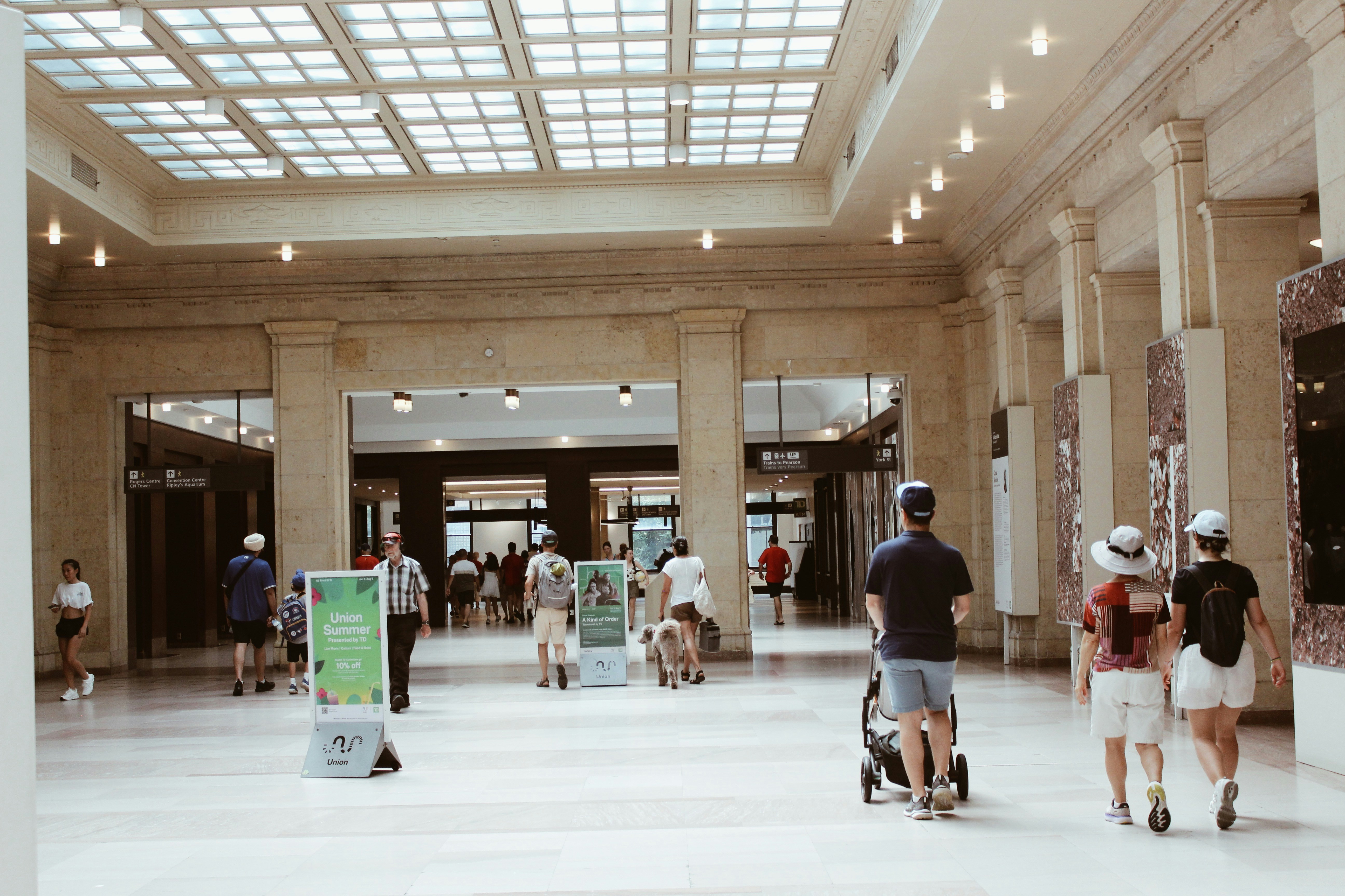 Atrium Moment: Shoppers Enter a Sunlit Gallery Corridor