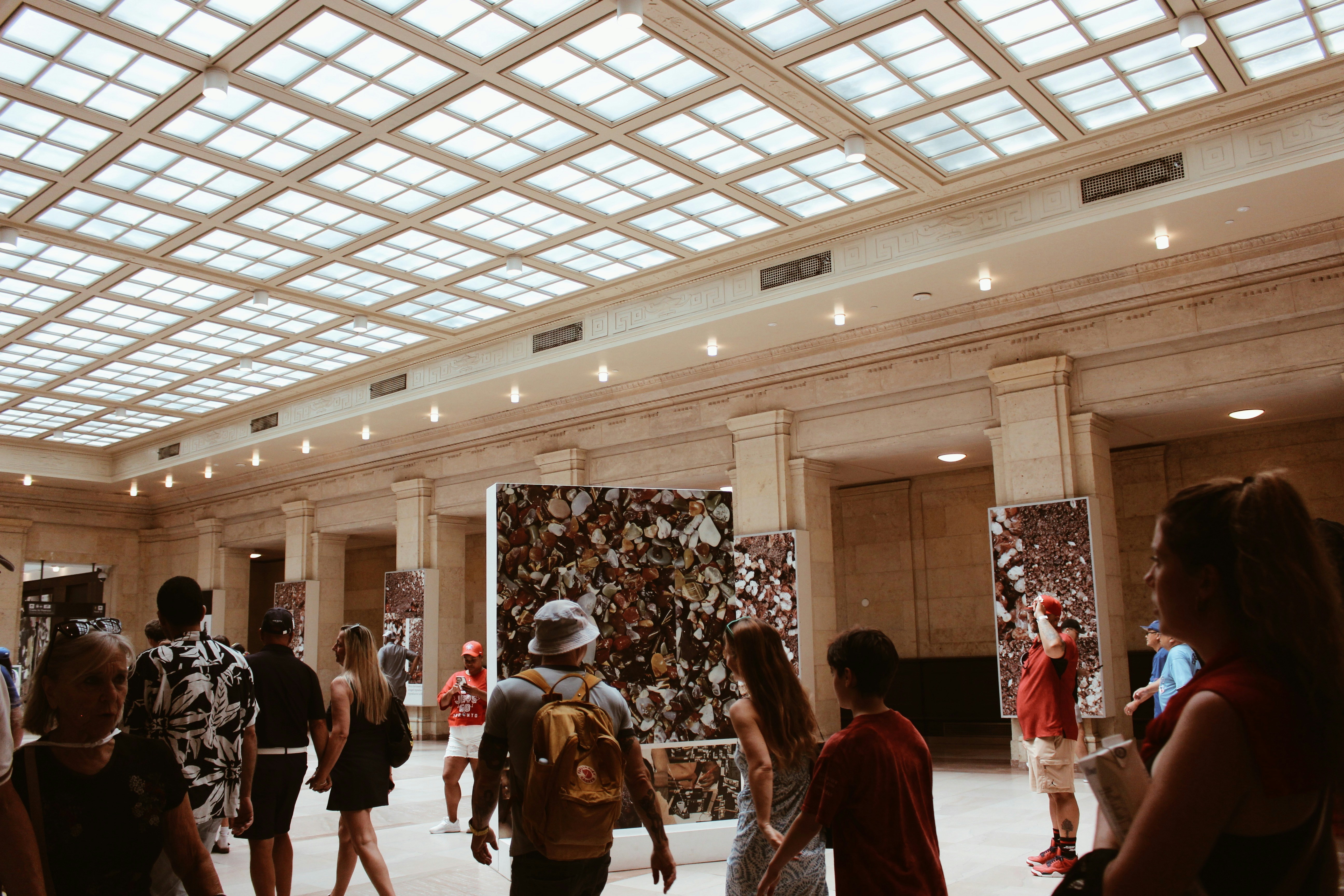 Crowd beneath Glass Ceiling: Gallery Visitors in a Sunlit Atrium