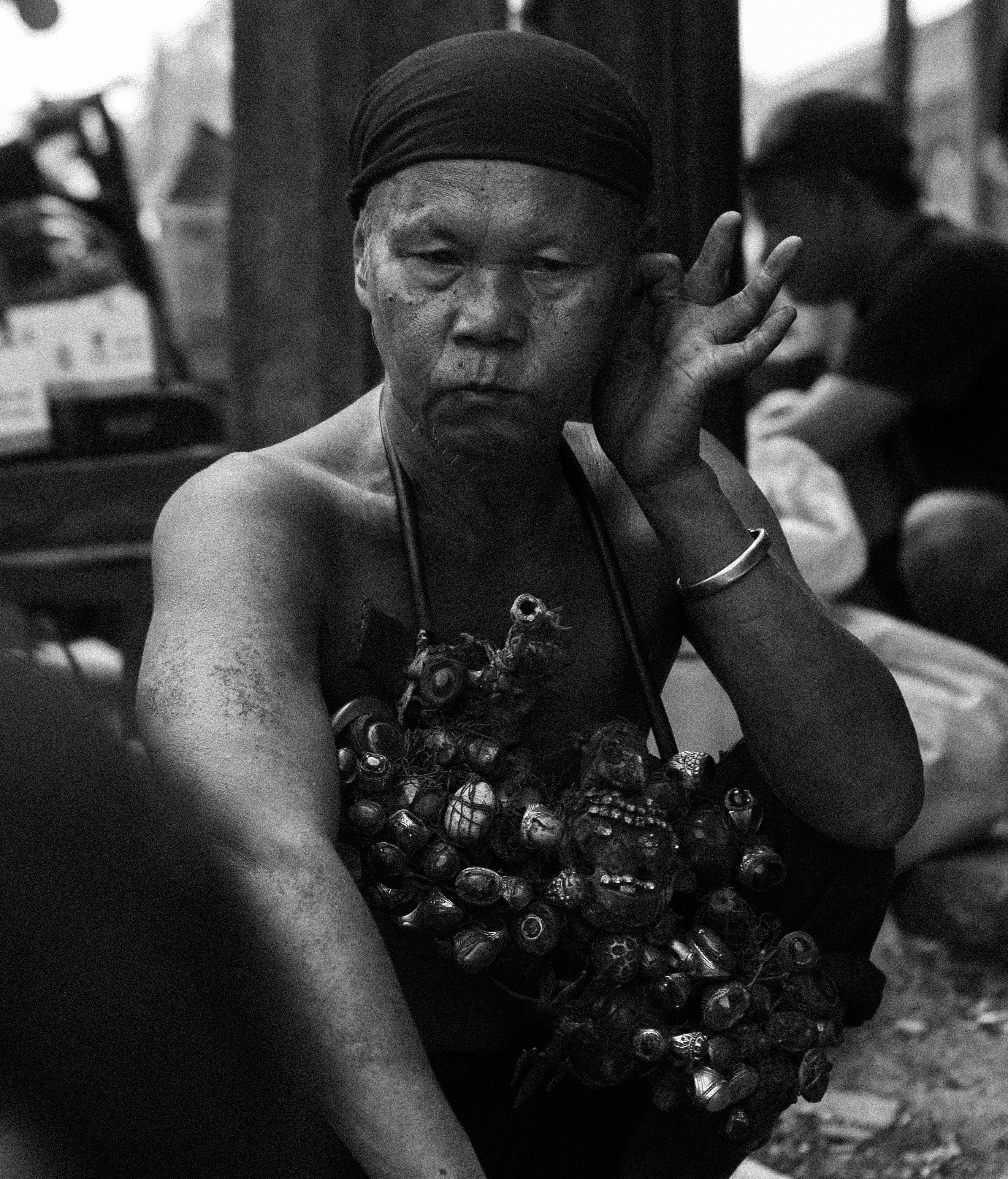 Portrait of Contemplation: Elderly Vendor Amid Curios
