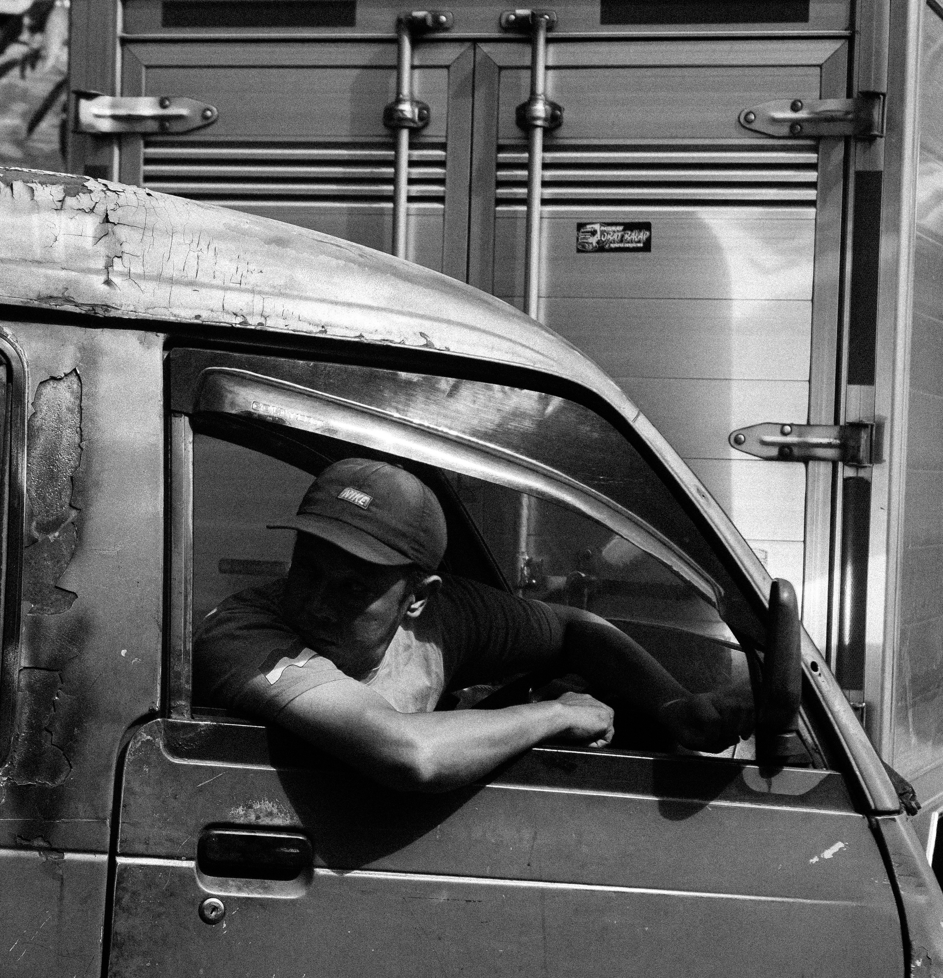 Driver in the Shadow: A Grayscale Glimpse from a Truck Window