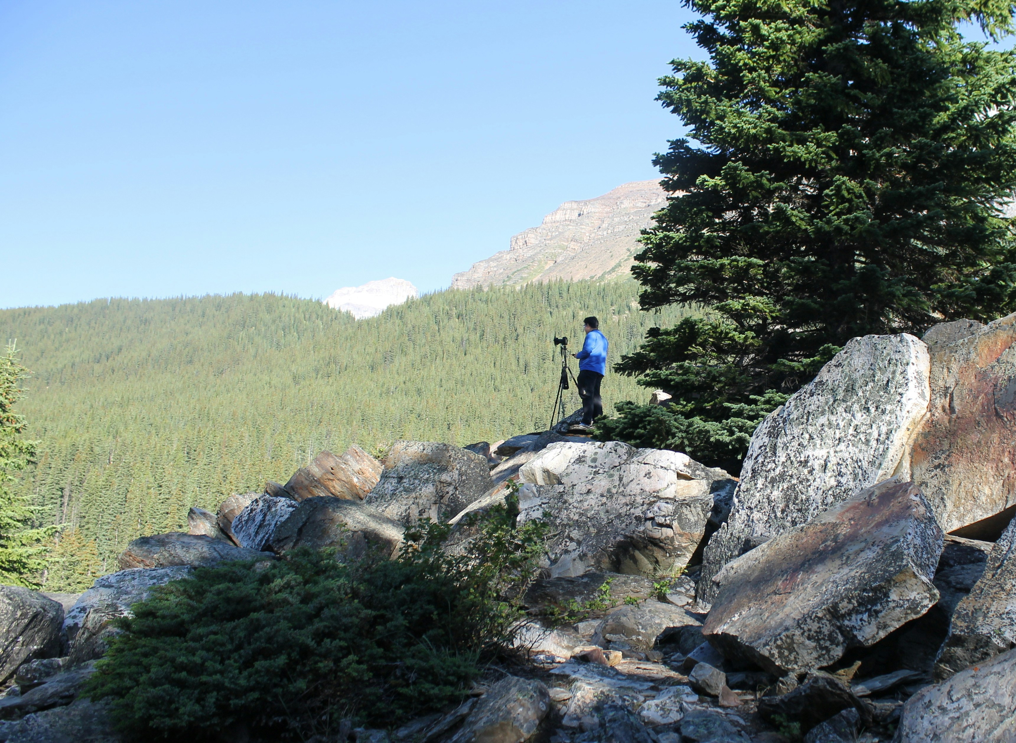Ridge Top: a lone photographer steadies a tripod against rocky foreground