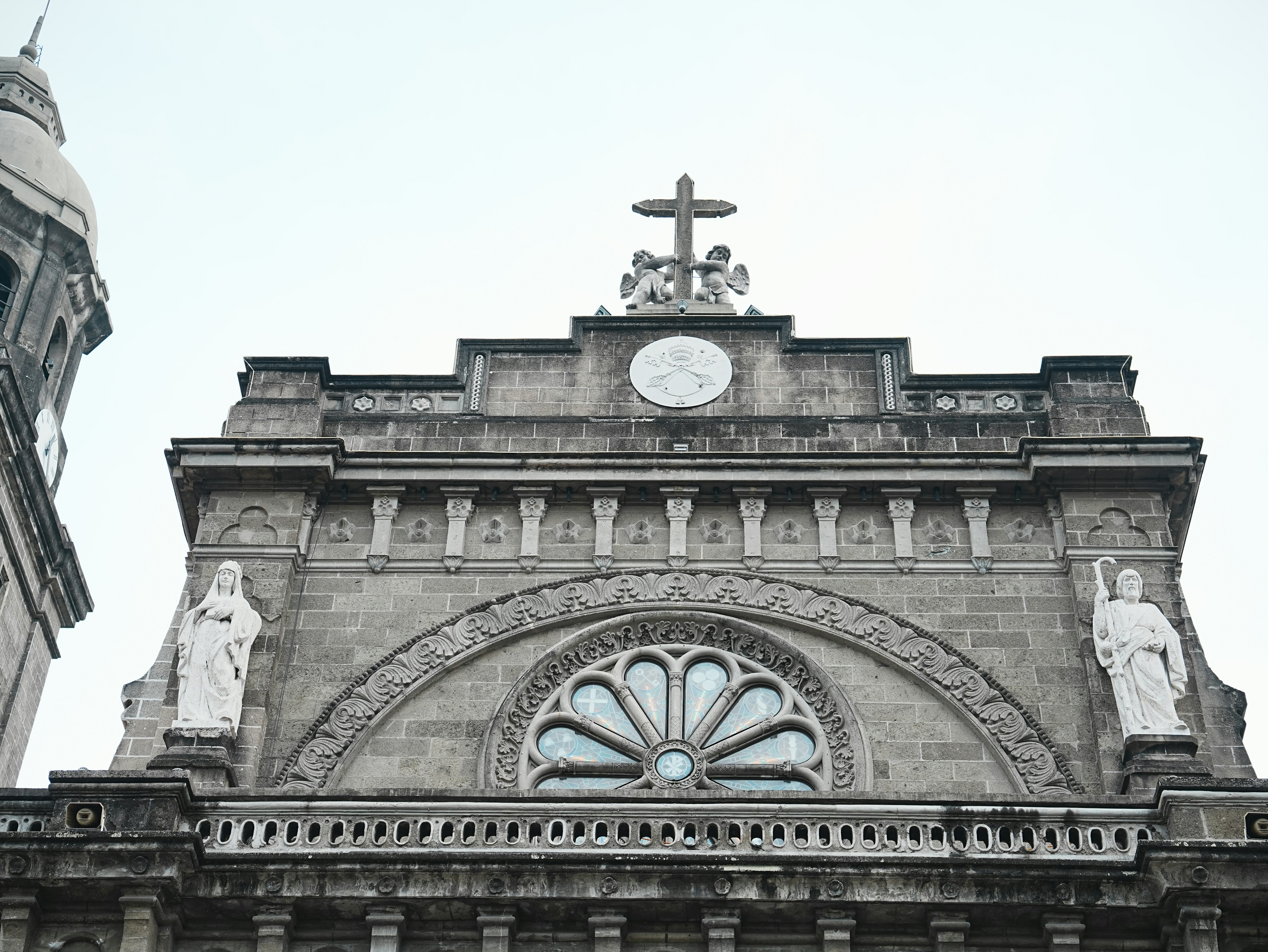 Arched Rose Window and Cross: Facade of a Historic Cathedral