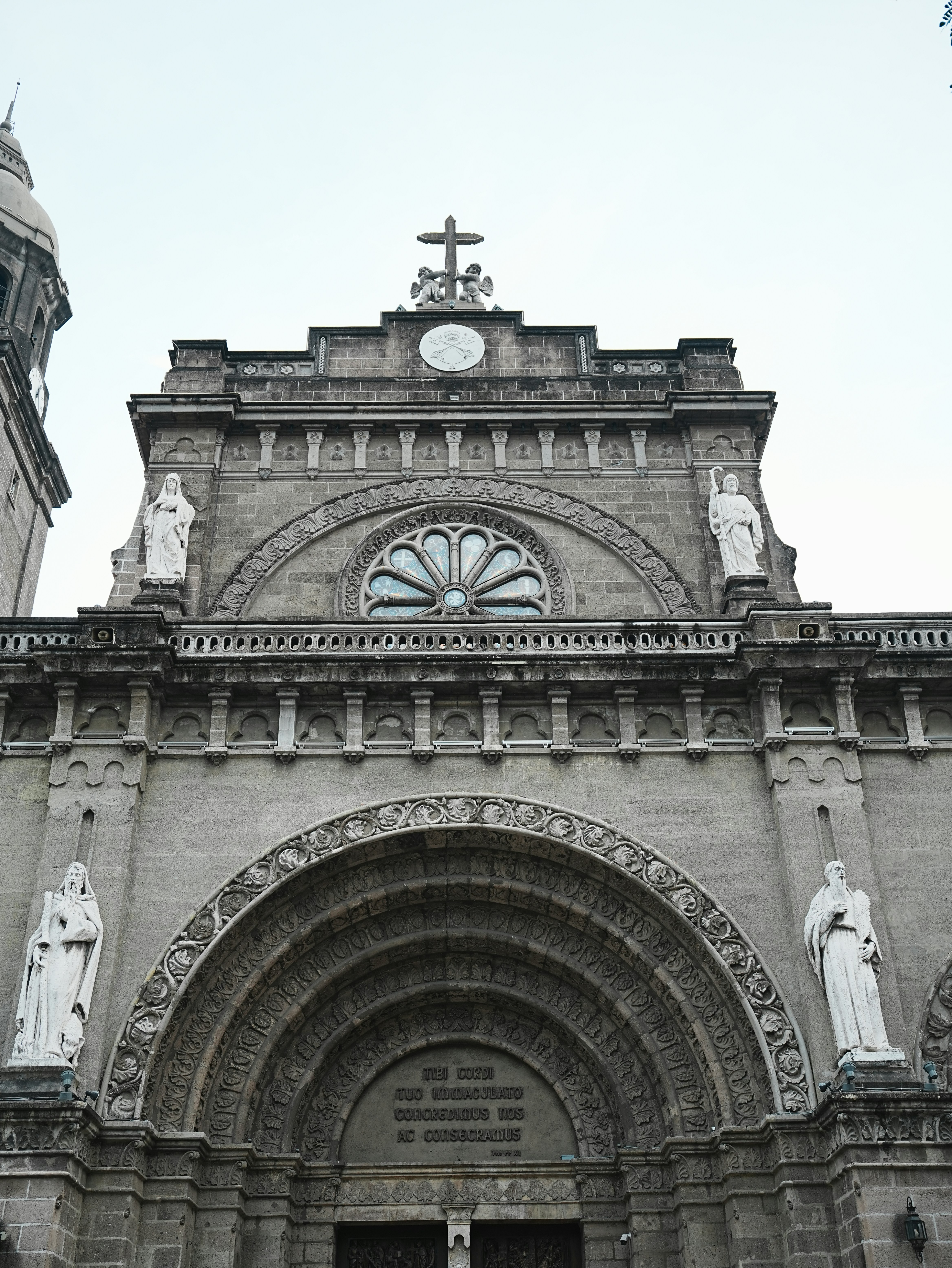 Arched Basilica Facade: Stone Ornaments and Centered Oculus