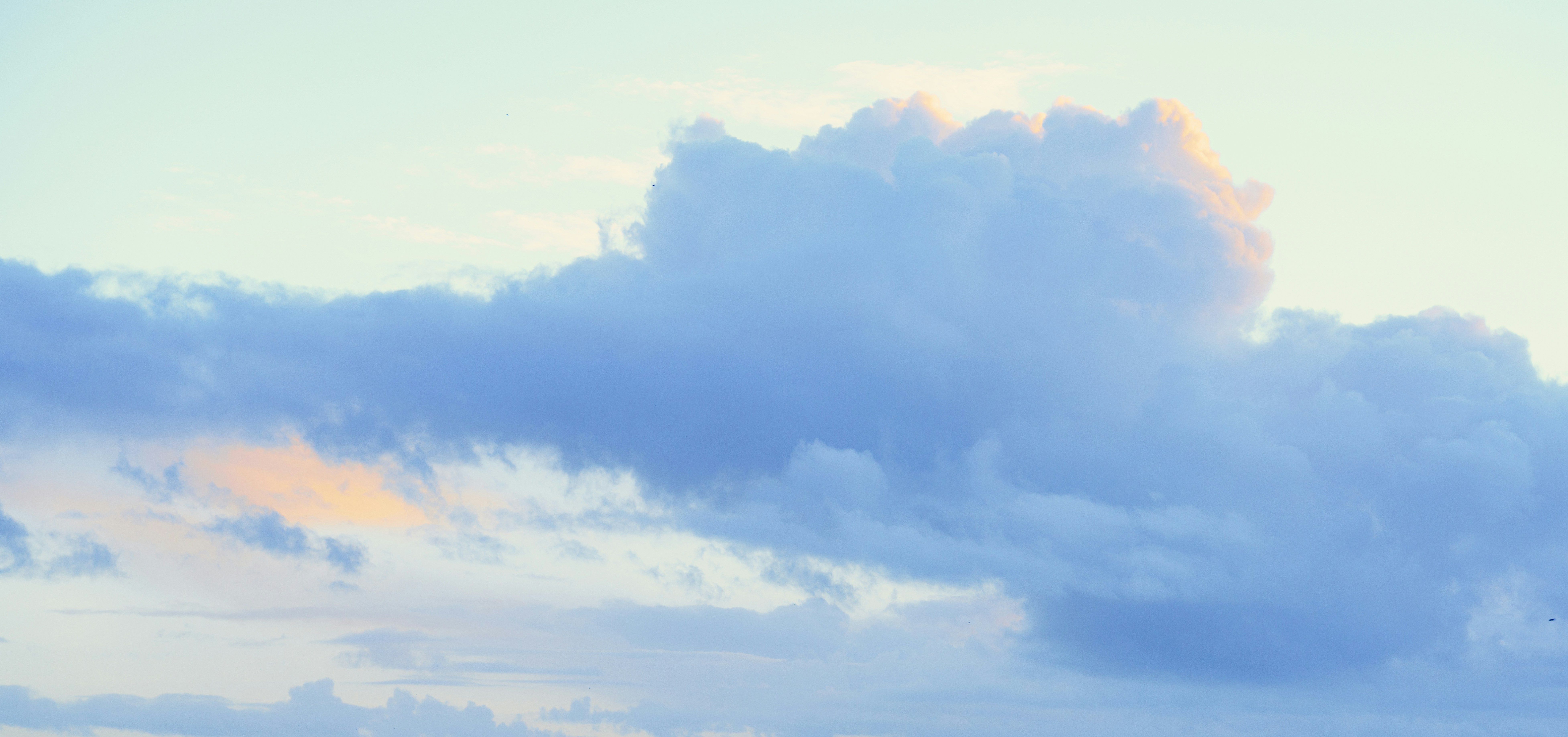 Cloudscape at Dusk: Soft Blue Peaks and Gentle Orange Highlight