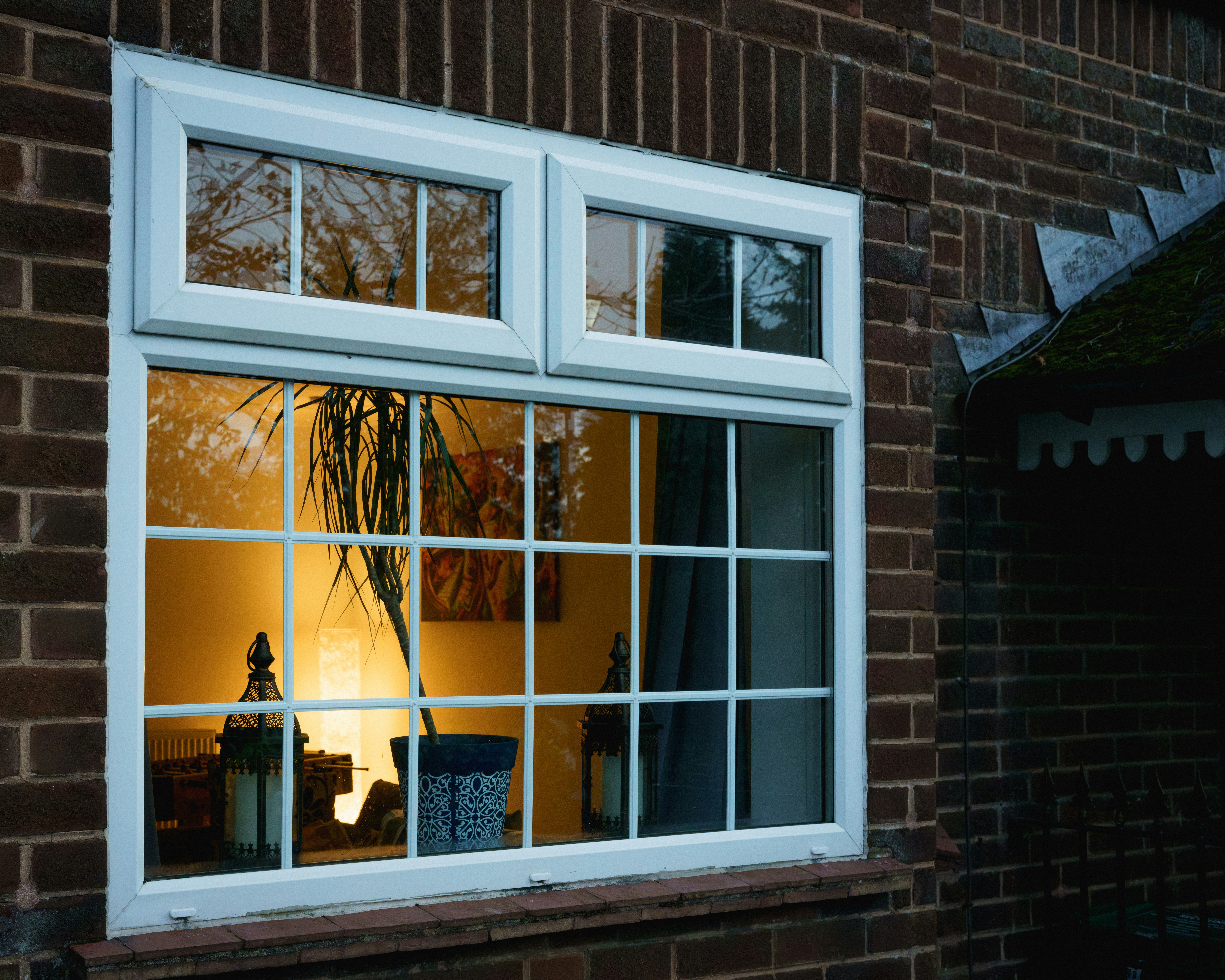 Warm Glow Through a Gridded Window on a Brick Facade