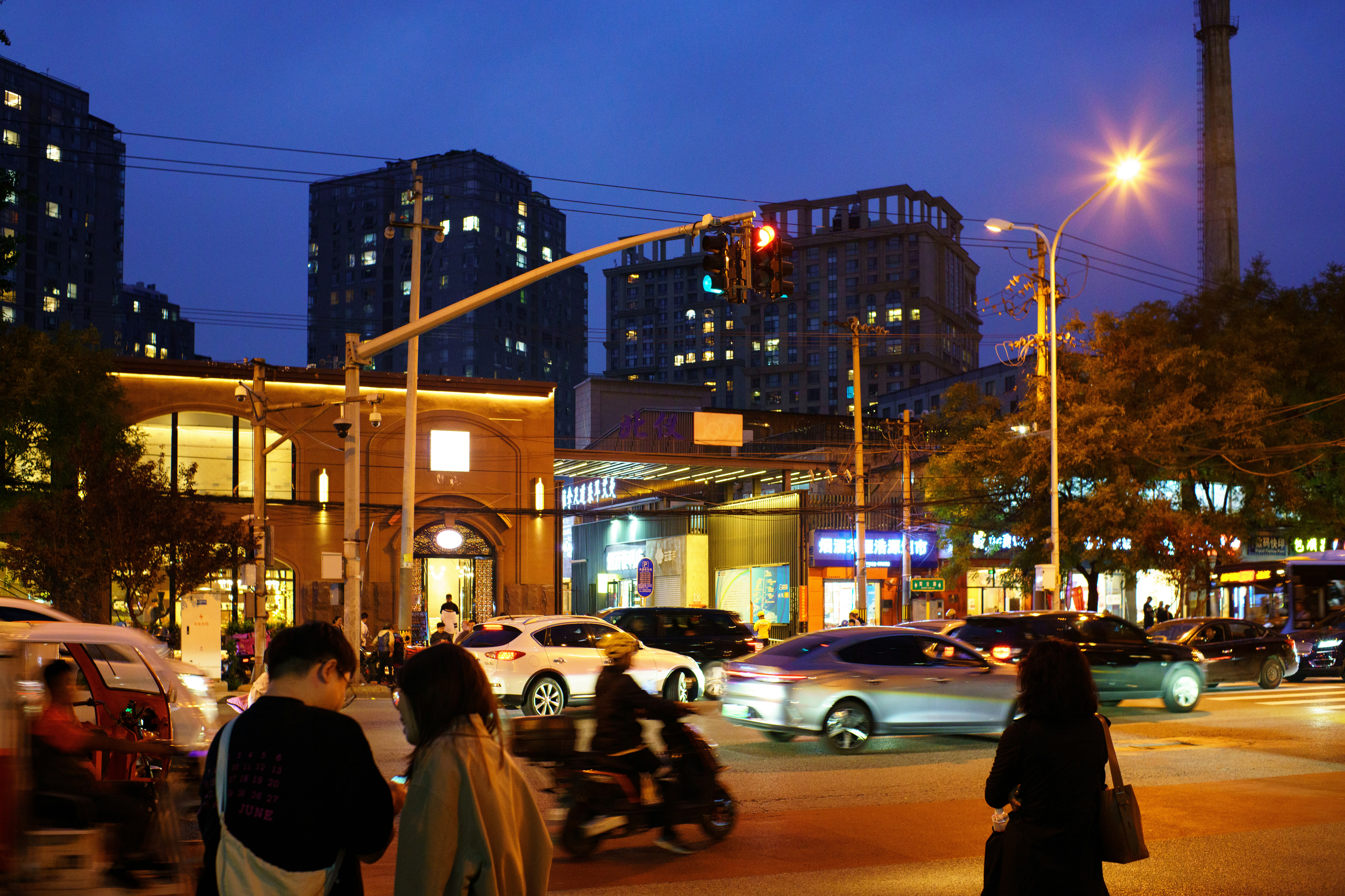 City Junction at Blue Hour: People, Cars, and Neon Lights