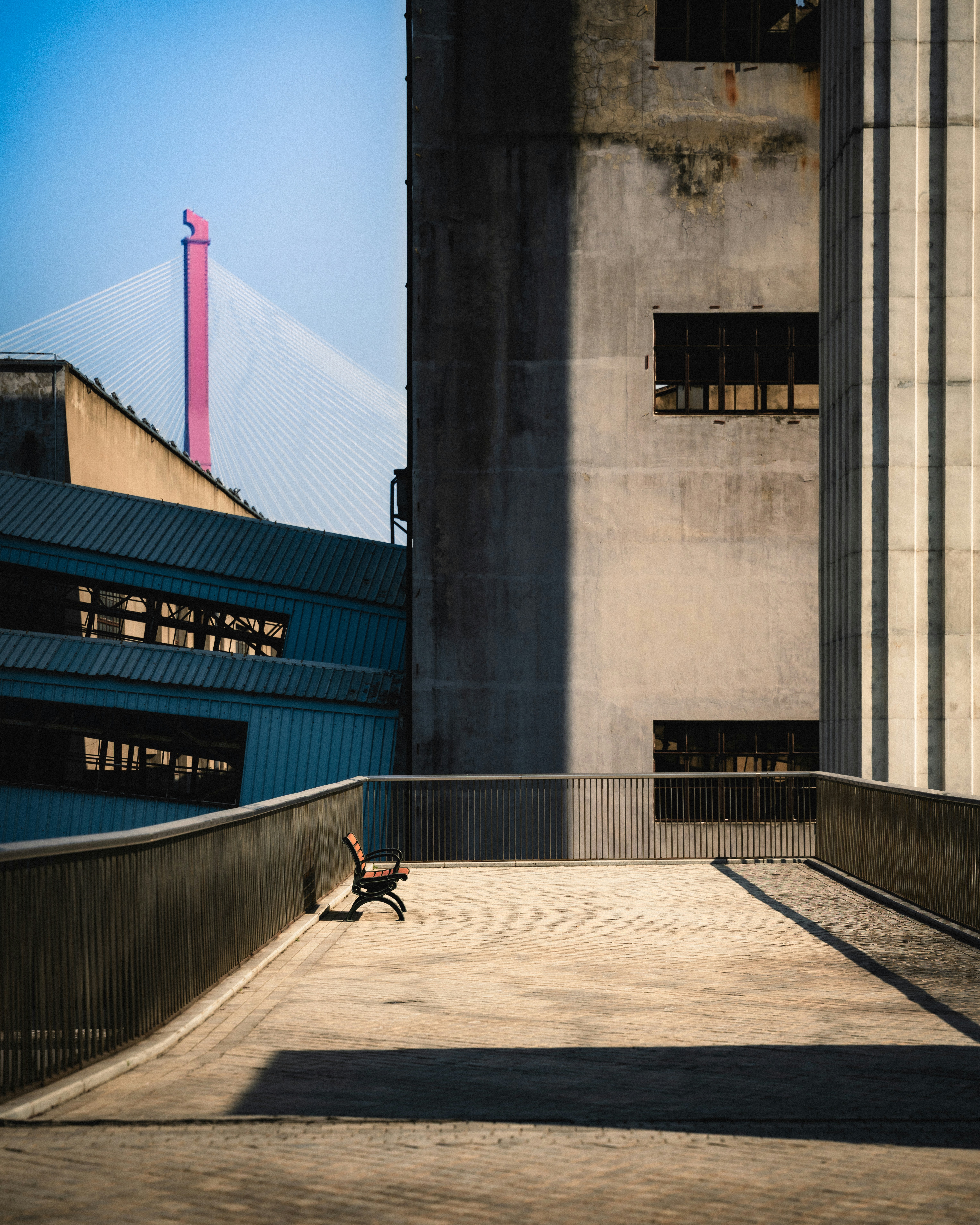 Urban Silence: A Solitary Bench Beneath Concrete Geometry