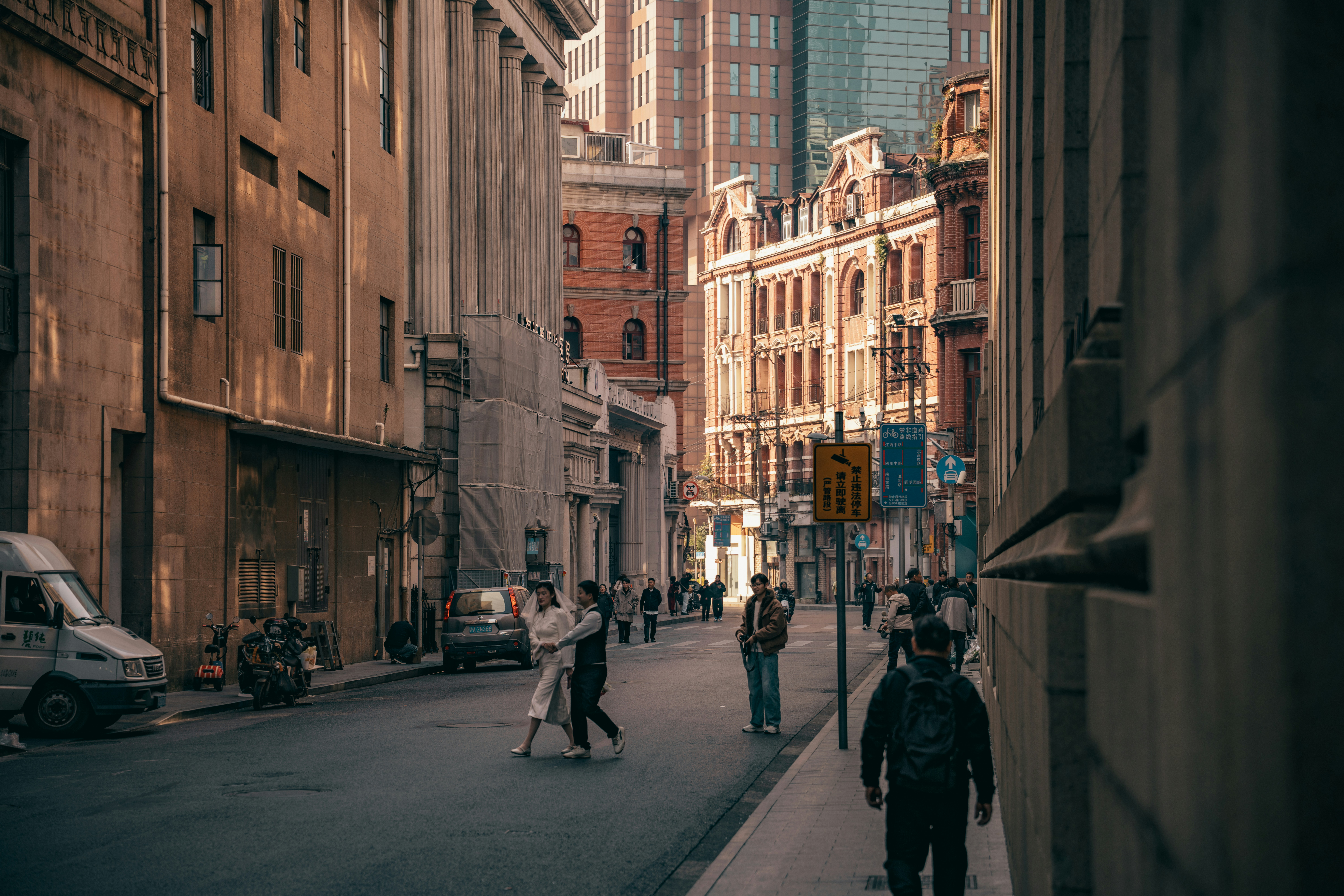 City Street in Warm Evening Light with Pedestrians and Historic Facades
