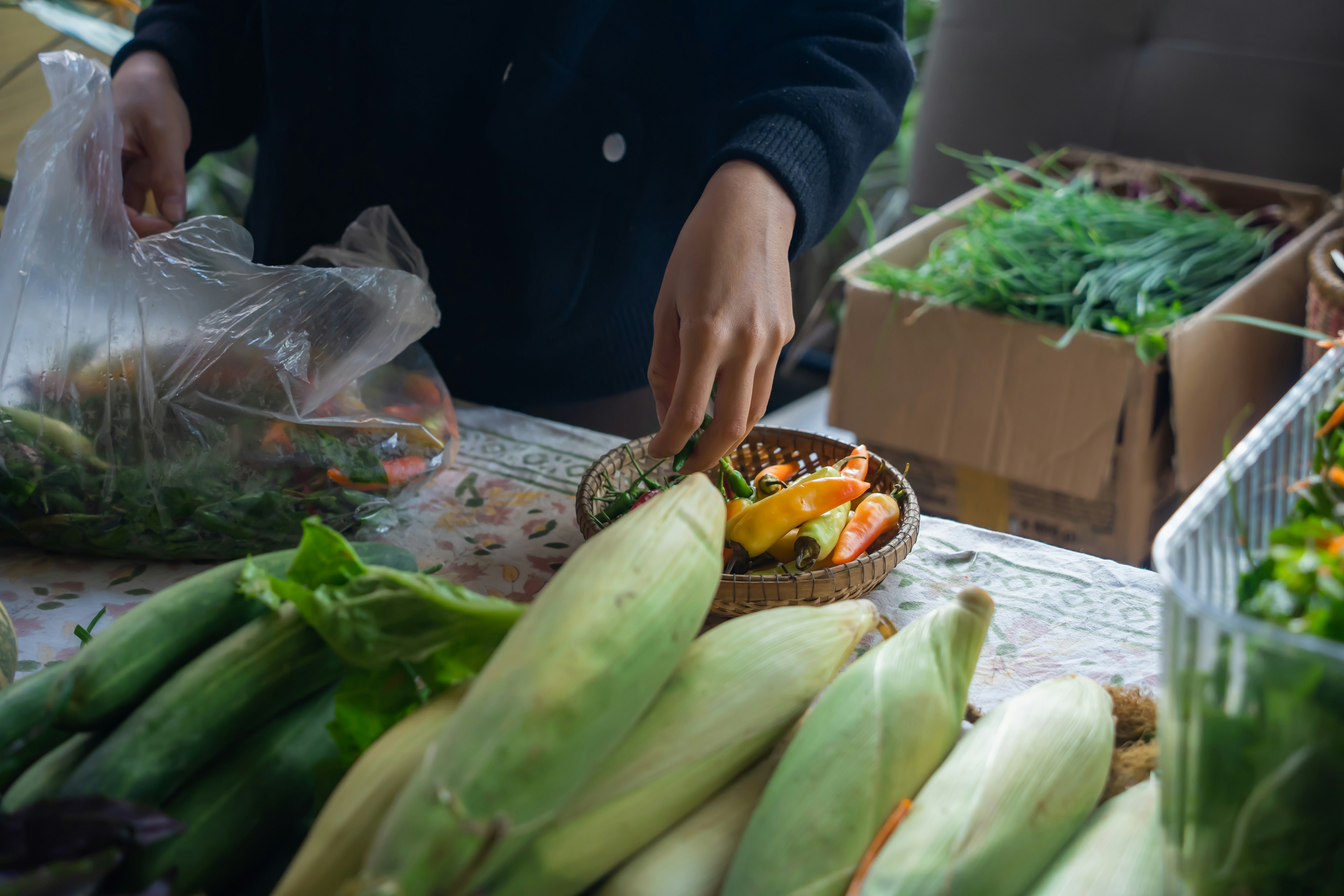 Hands at the Market: Fresh Corn and Greens Framed by Busy Hands