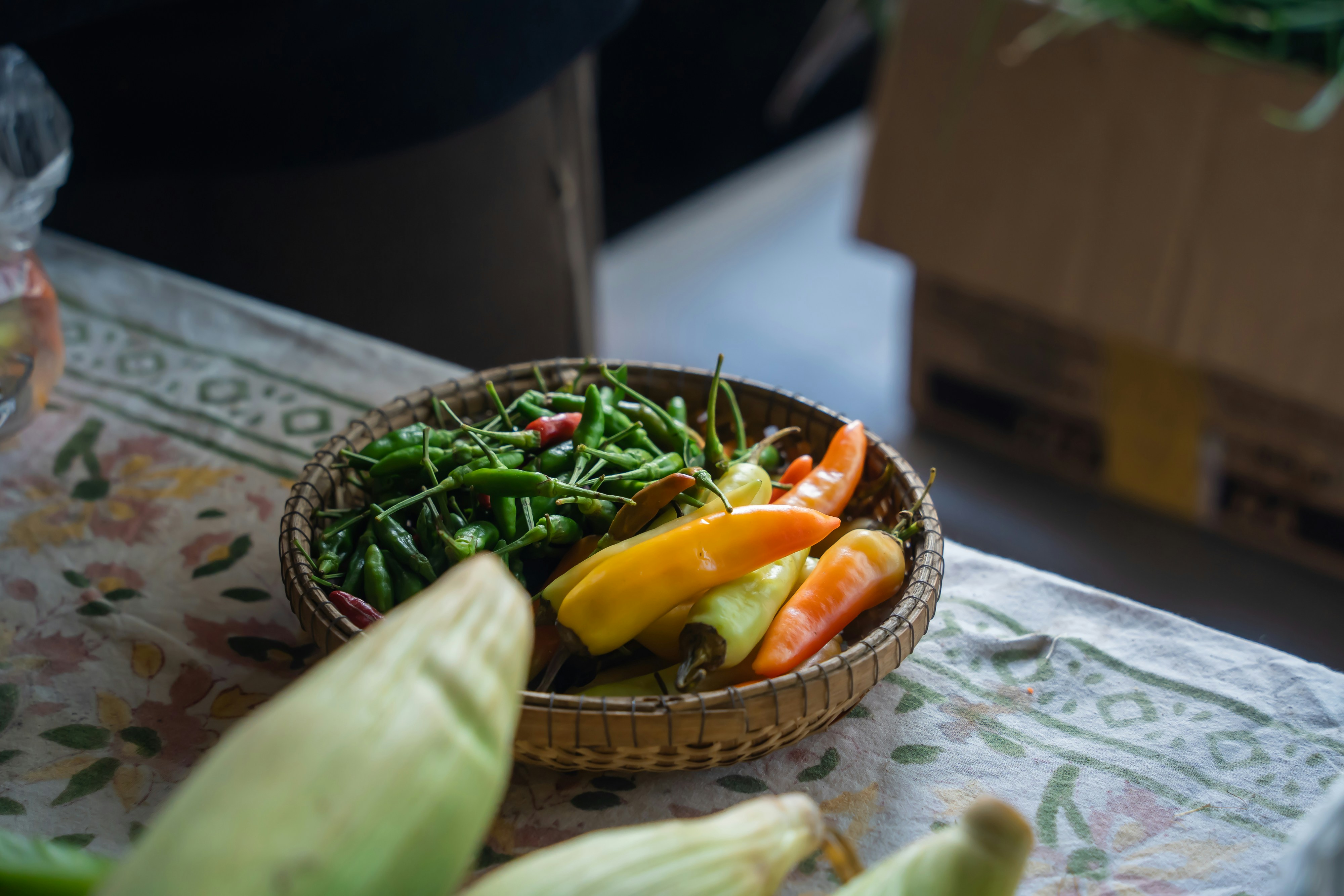 Colorful Pepper Basket on a Florally Patterned Table