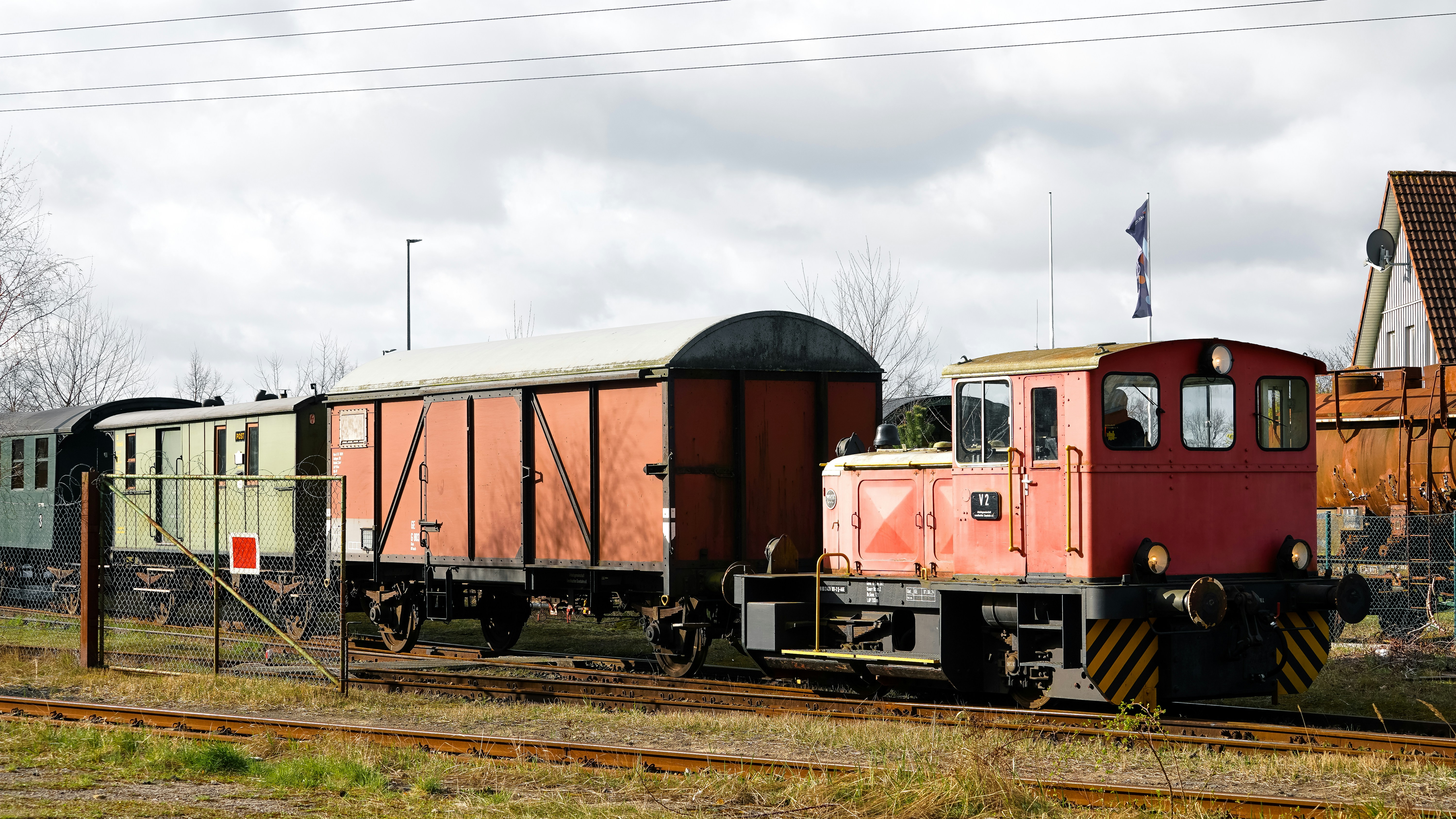 Old Rail Yard: A Red Workhorse and Faded Carriages