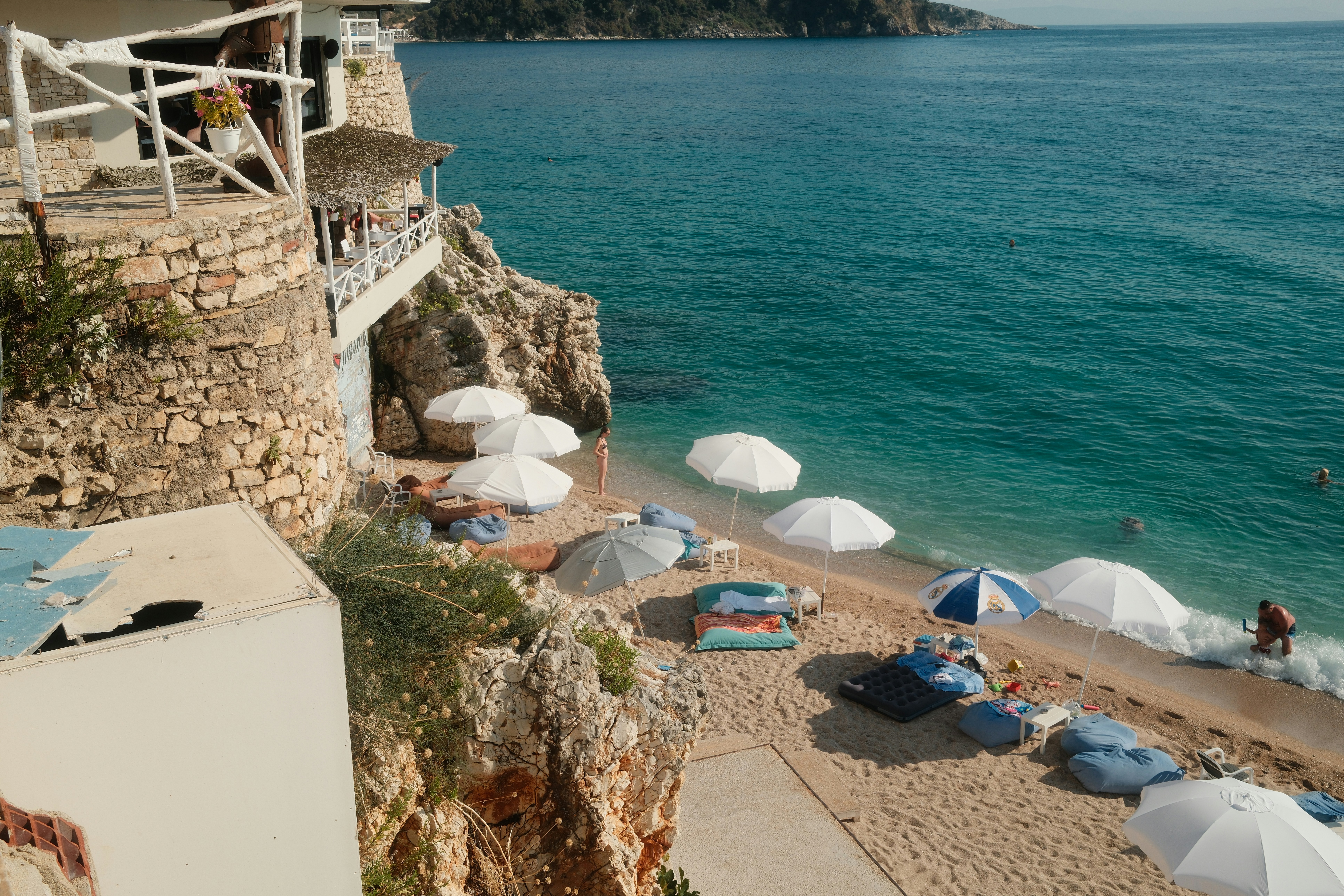 Terraced Beachfront with White Umbrellas Over Turquoise Shore