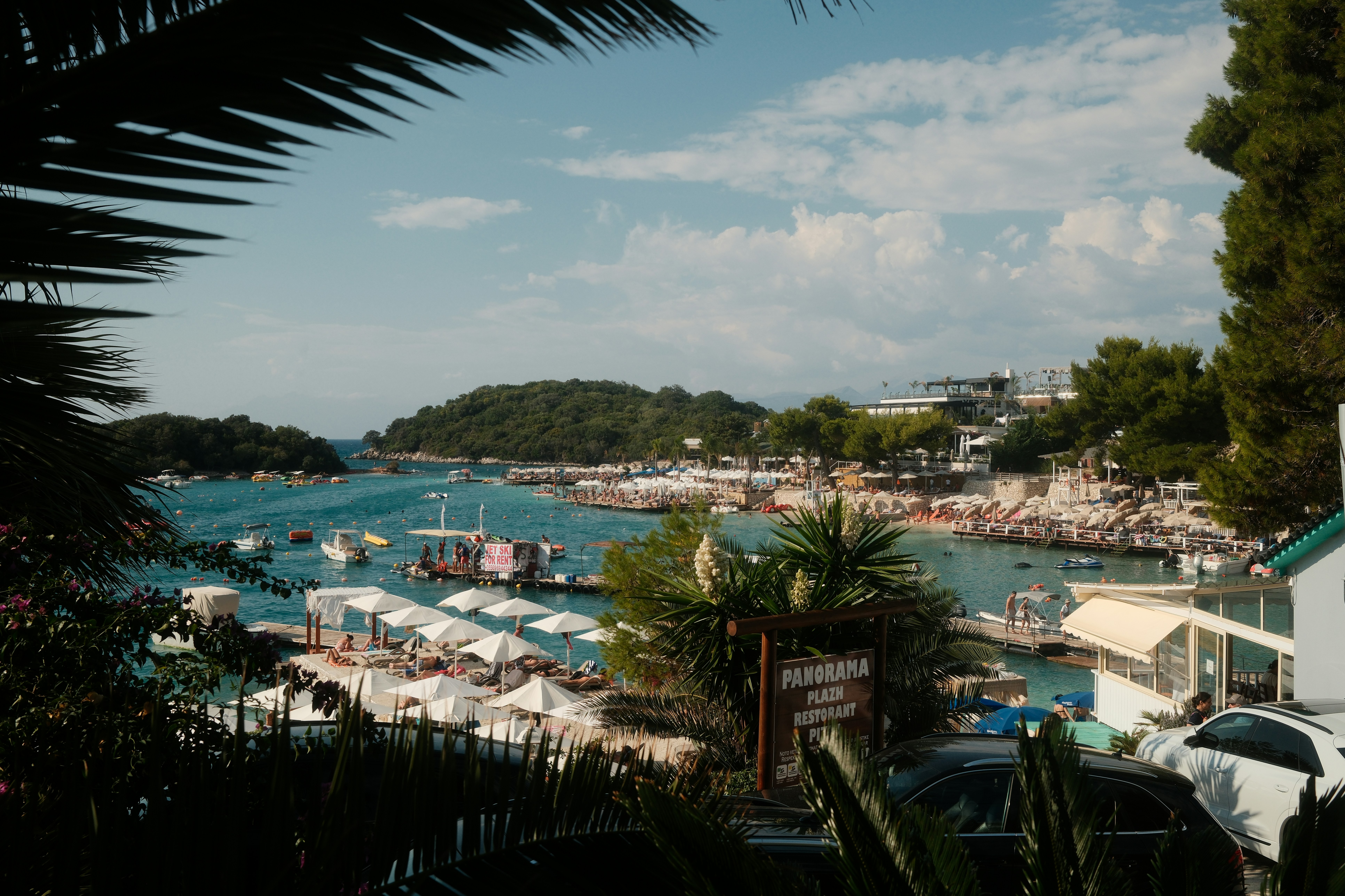 Sunlit Marina Rhythm: Boats, Beachfront, and Palms in Coastal Calm