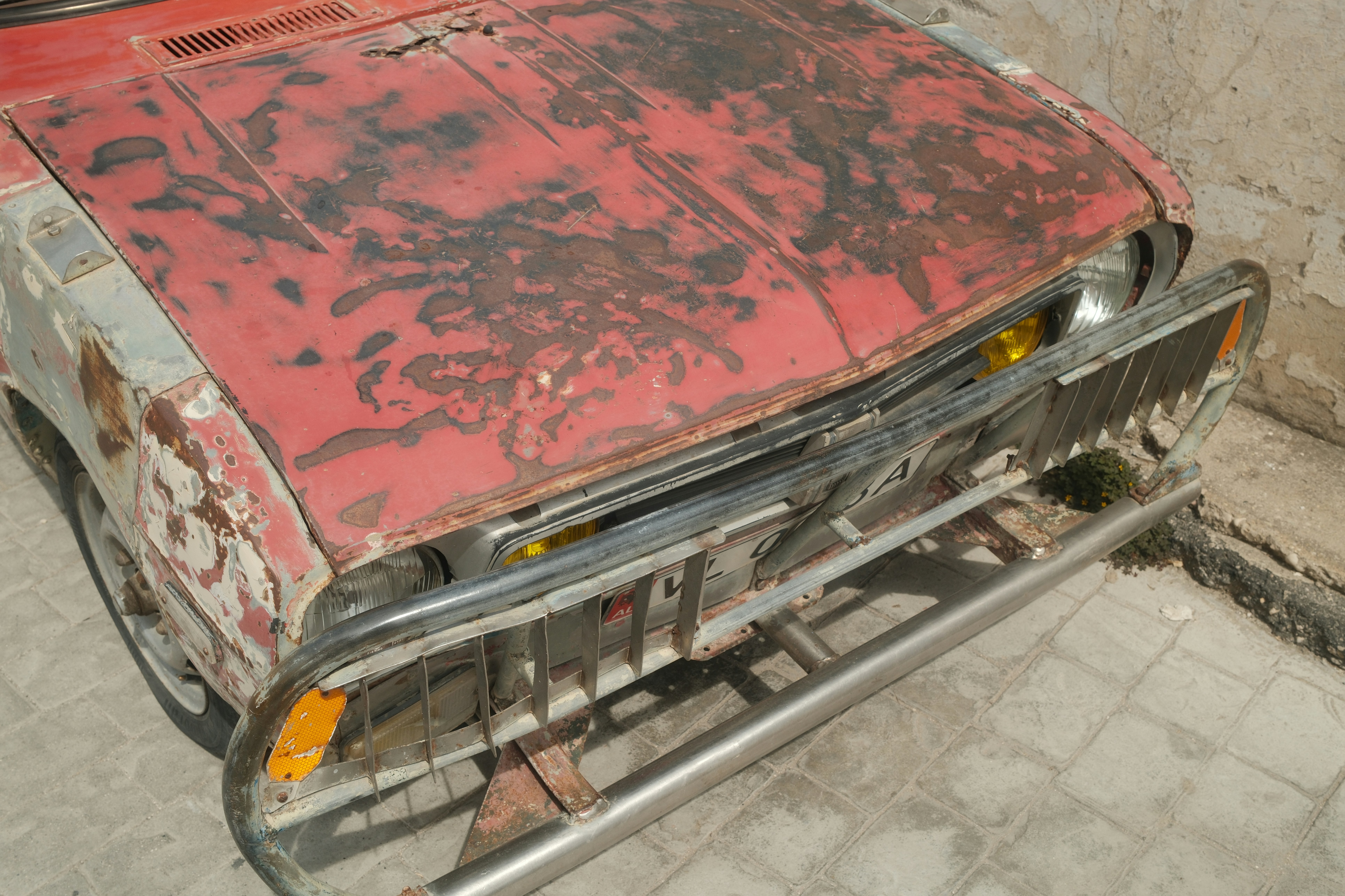 Worn Red Patrol: A Rusted Classic Guarding the Sidewalk