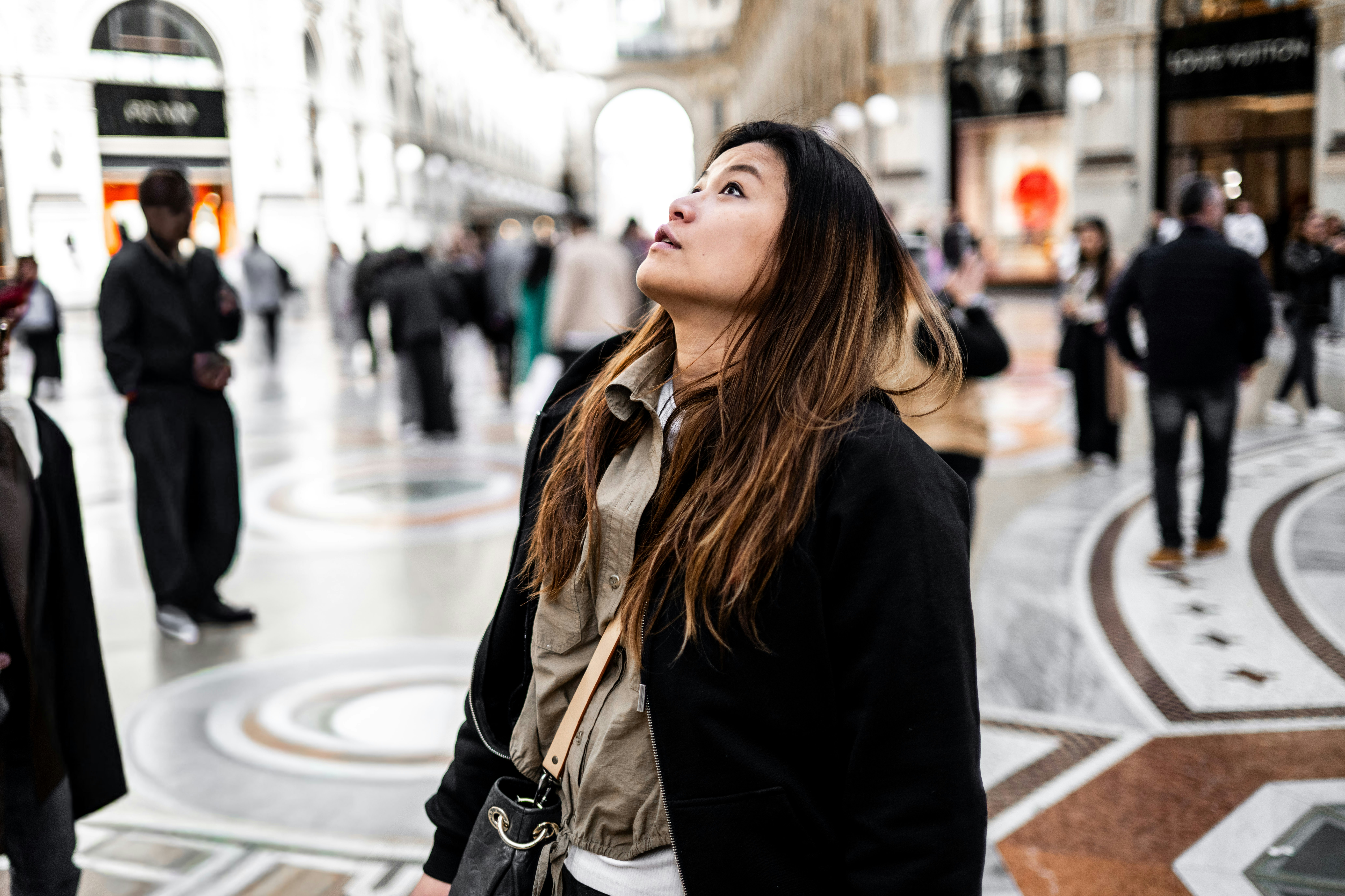 Medium-Long Shot of a Woman Gazing Up in a Busy Indoor Atrium