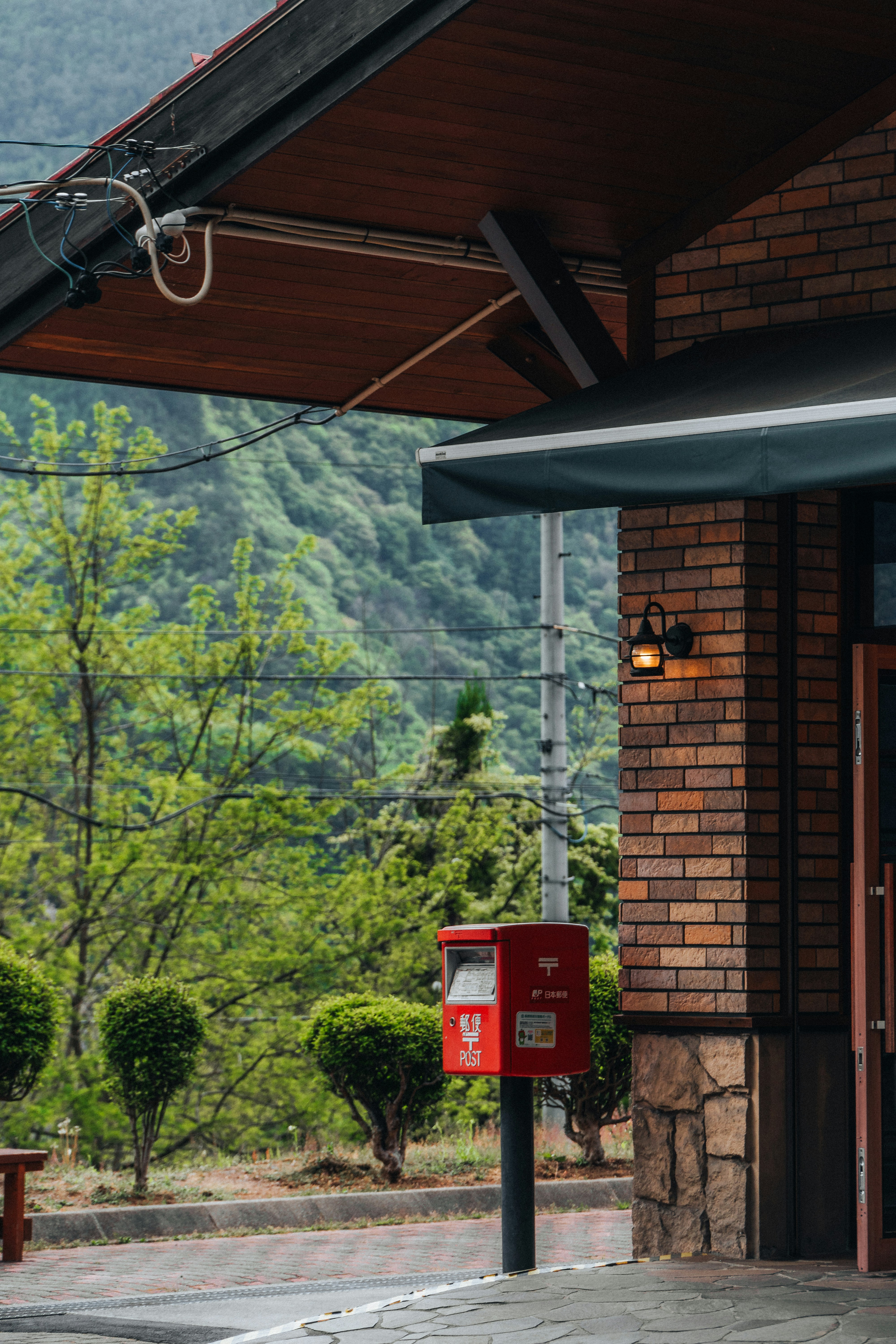 Red Mailbox by a Brick-Joisted Building in a Mountain Village