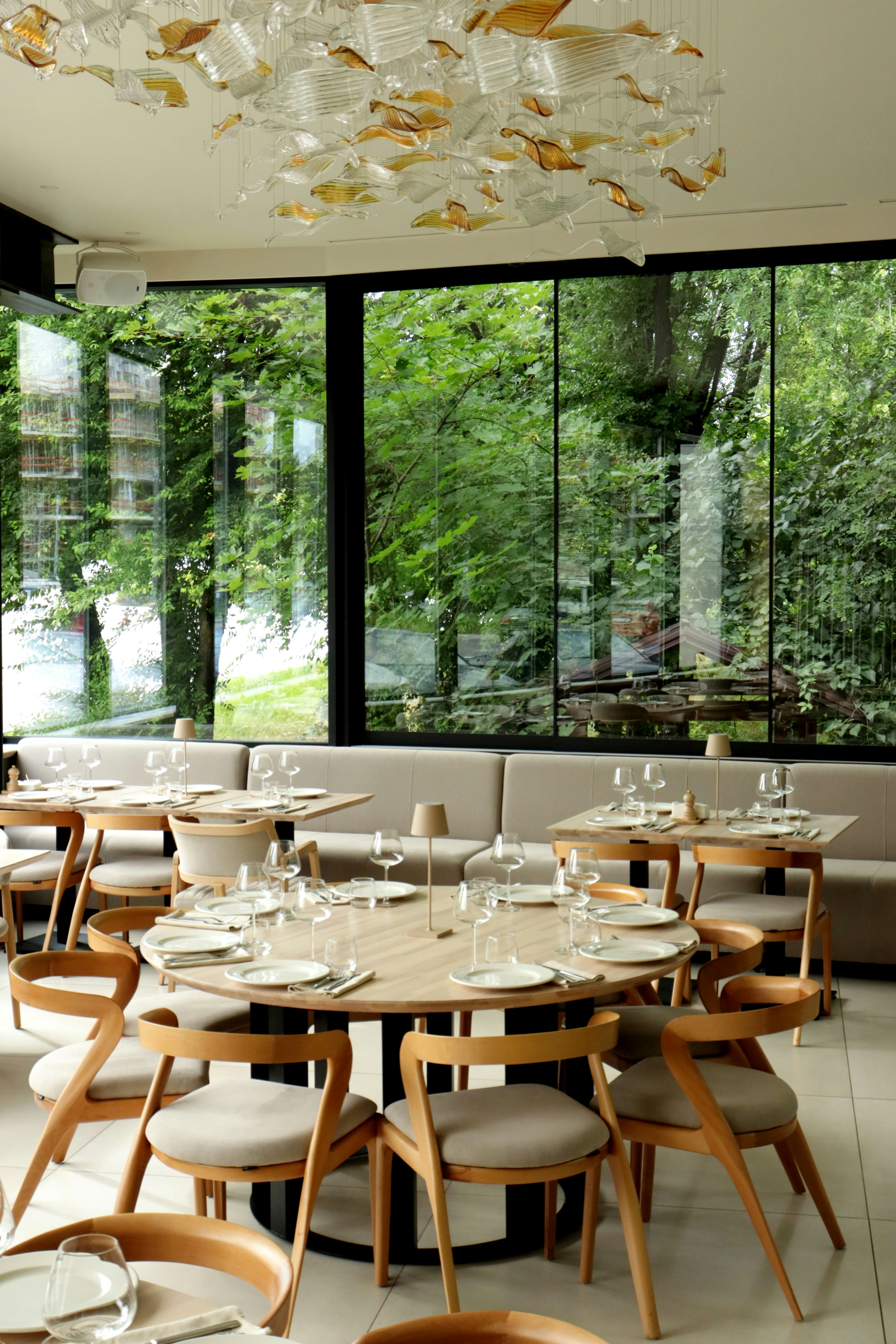 Sunlit Bistro at Dusk: A Circular Table Summit Beneath Glass and Greenery
