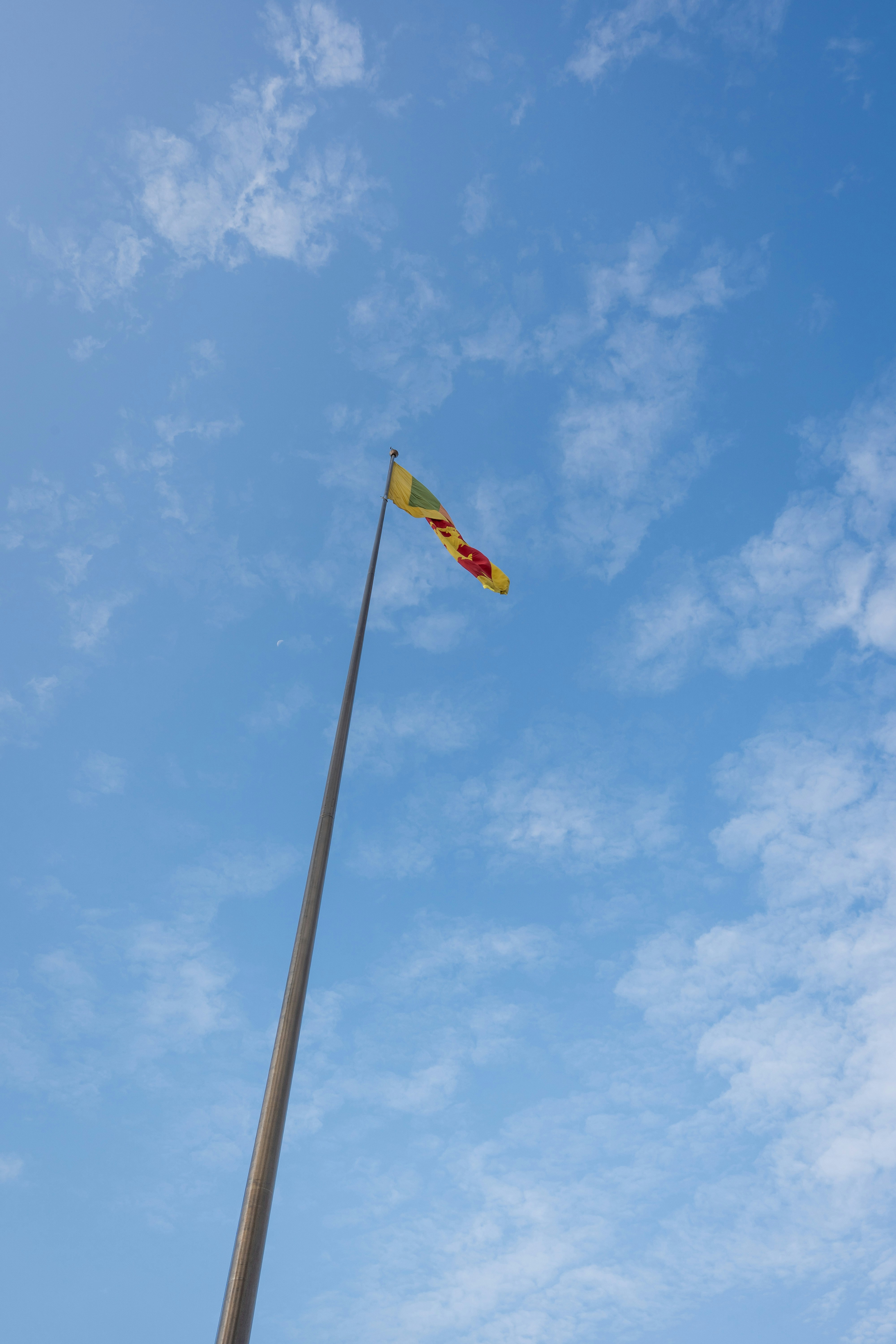 Flag on a Skyward Pole Under a Pale Blue Vastness