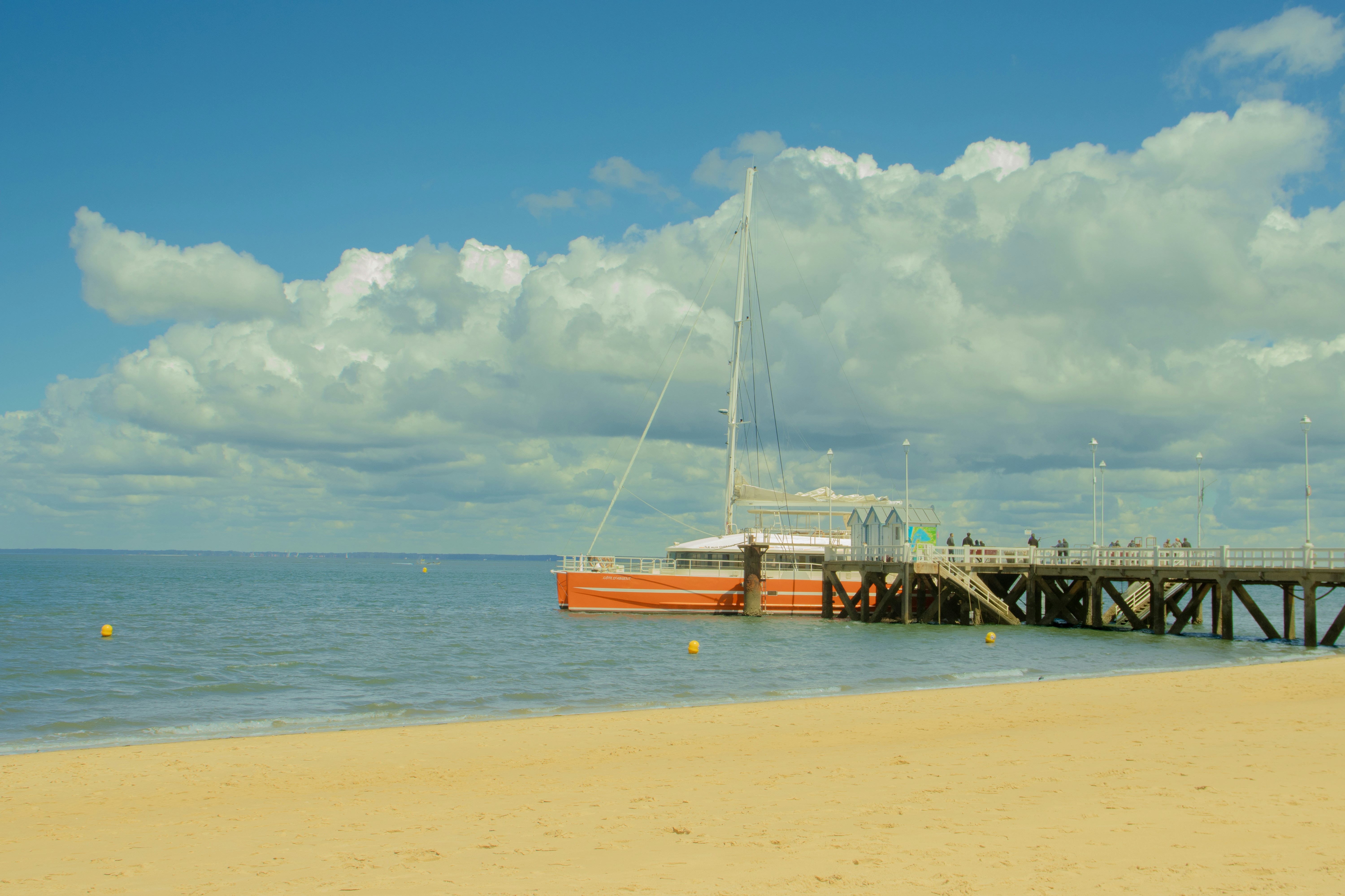 Sailboat at the End of the Pier on a Quiet Sunny Beach
