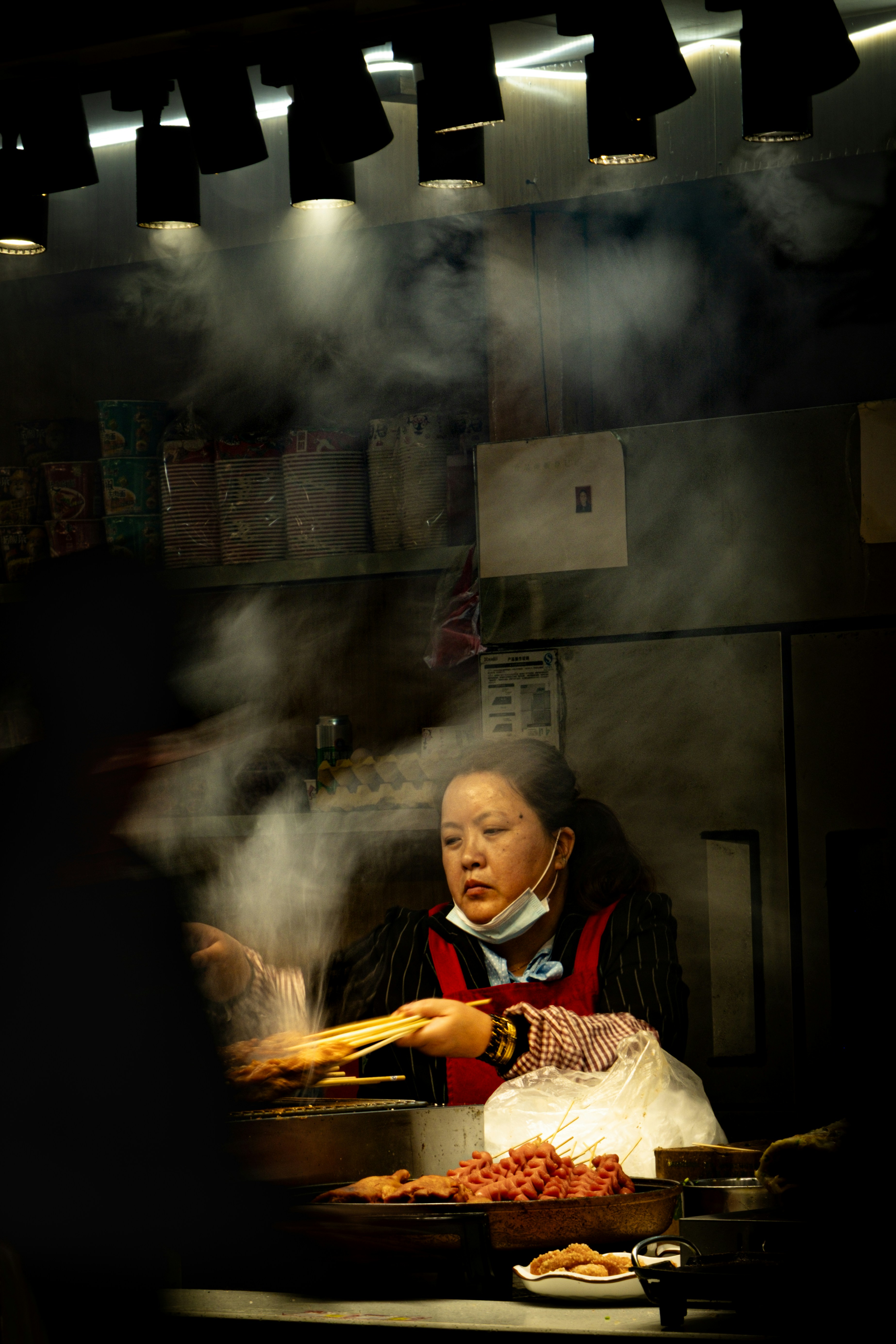 Steam and Spices: A Food Stall Worker in the Lantern Glow