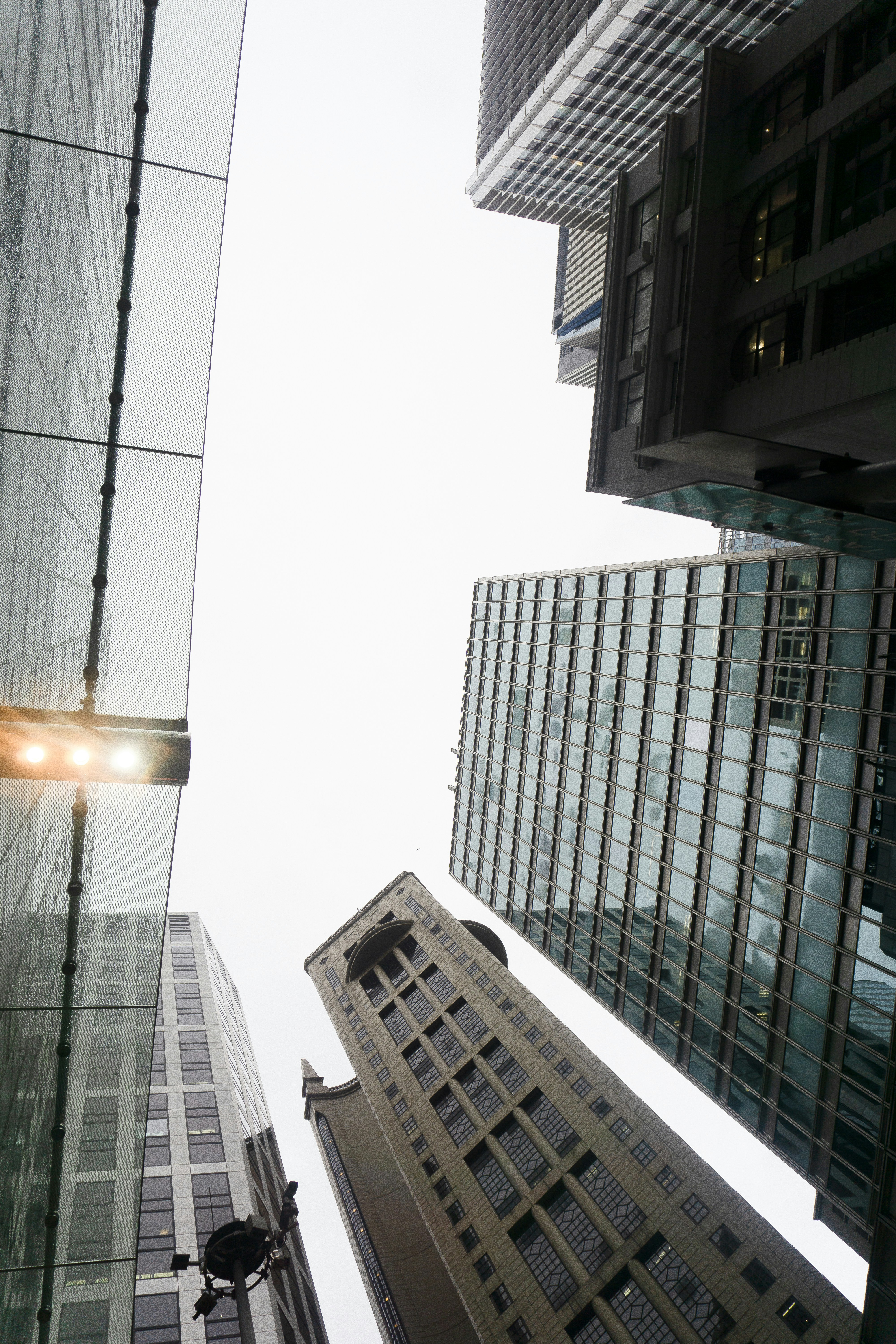 Urban Convergence: Skyscrapers Tilt Toward an Overcast Sky