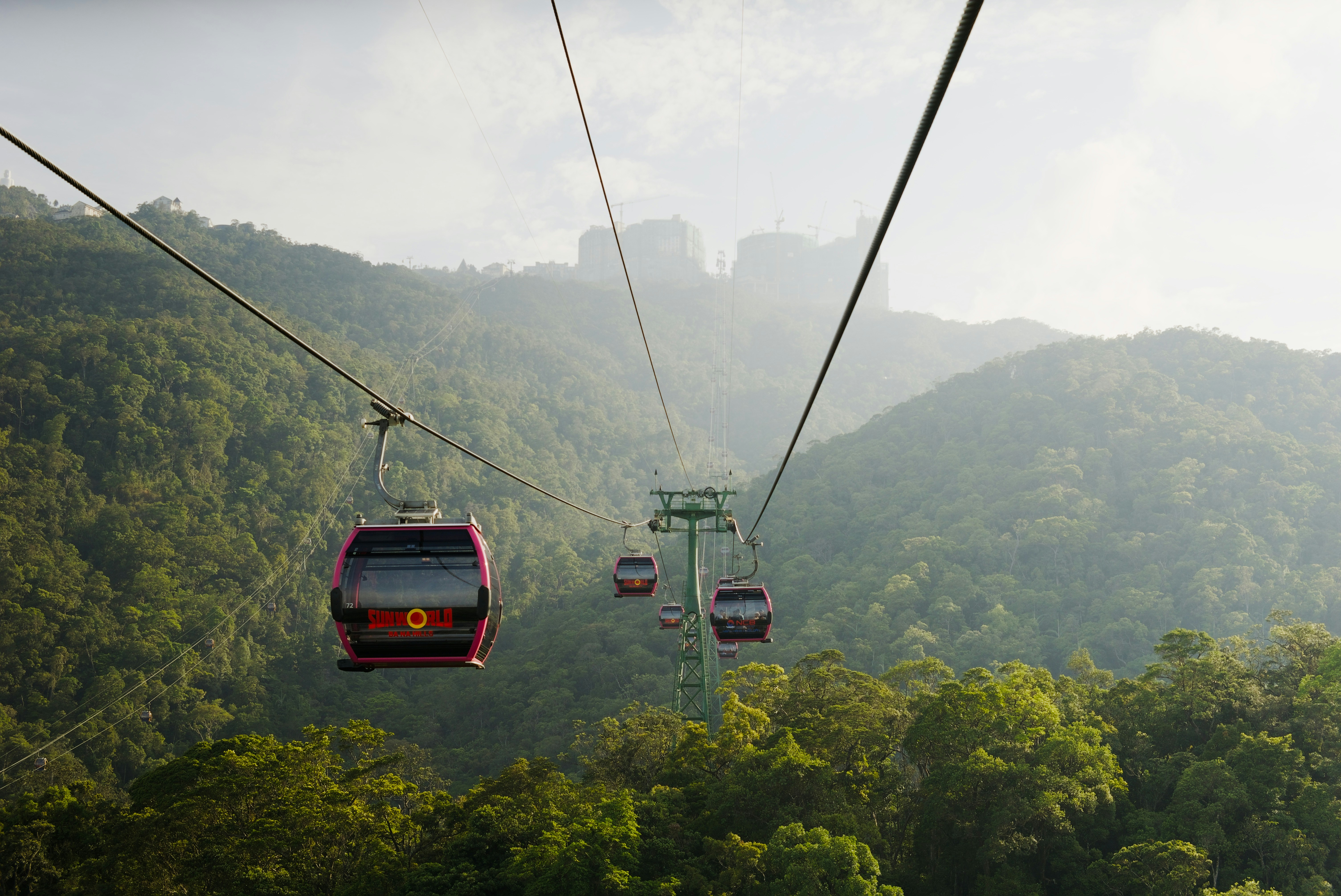 Skyward Lift: Cable Cars Drifting Through Misty Green Peaks