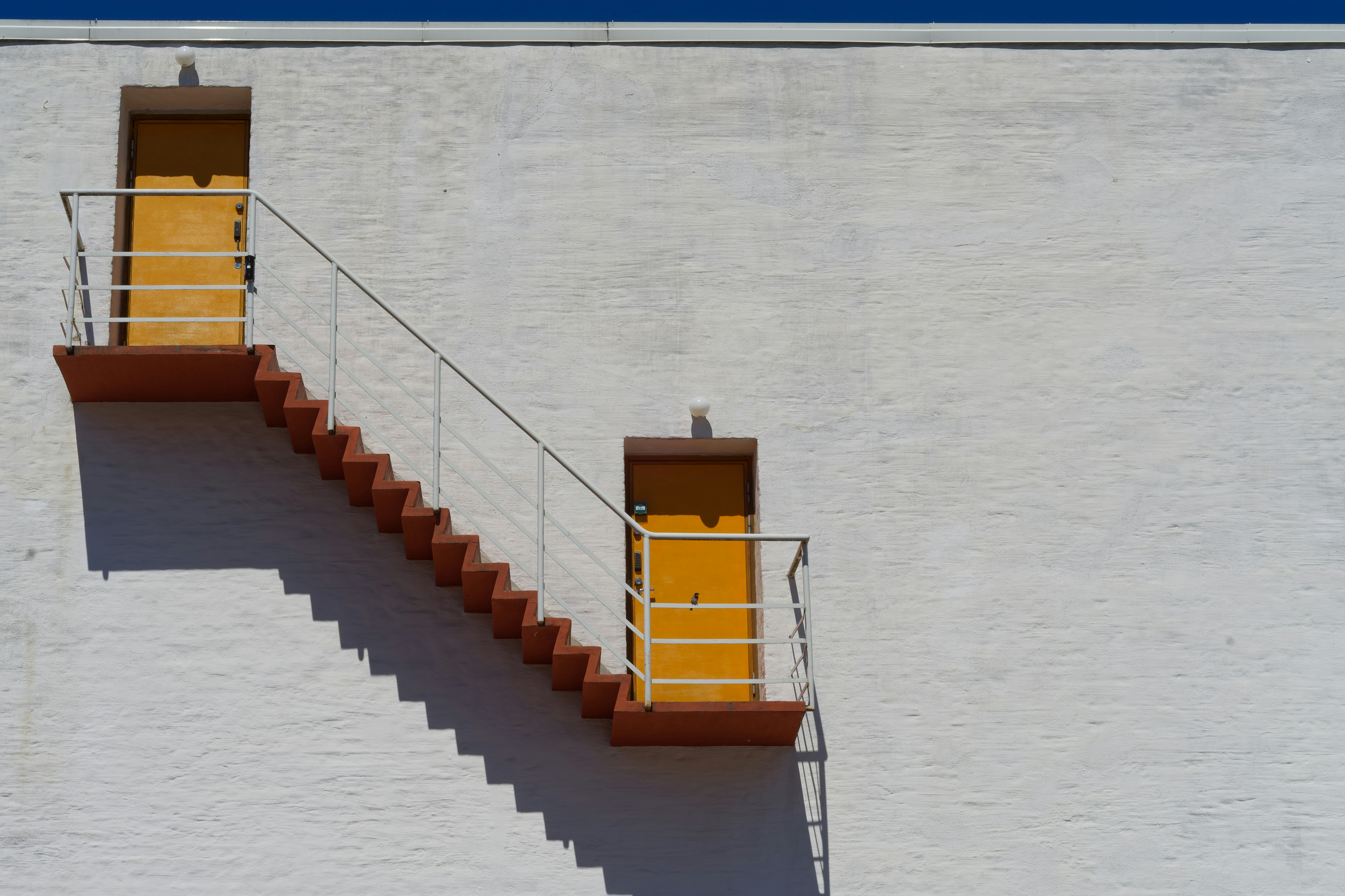 Orange Fire Iron Steps Across a White Wall