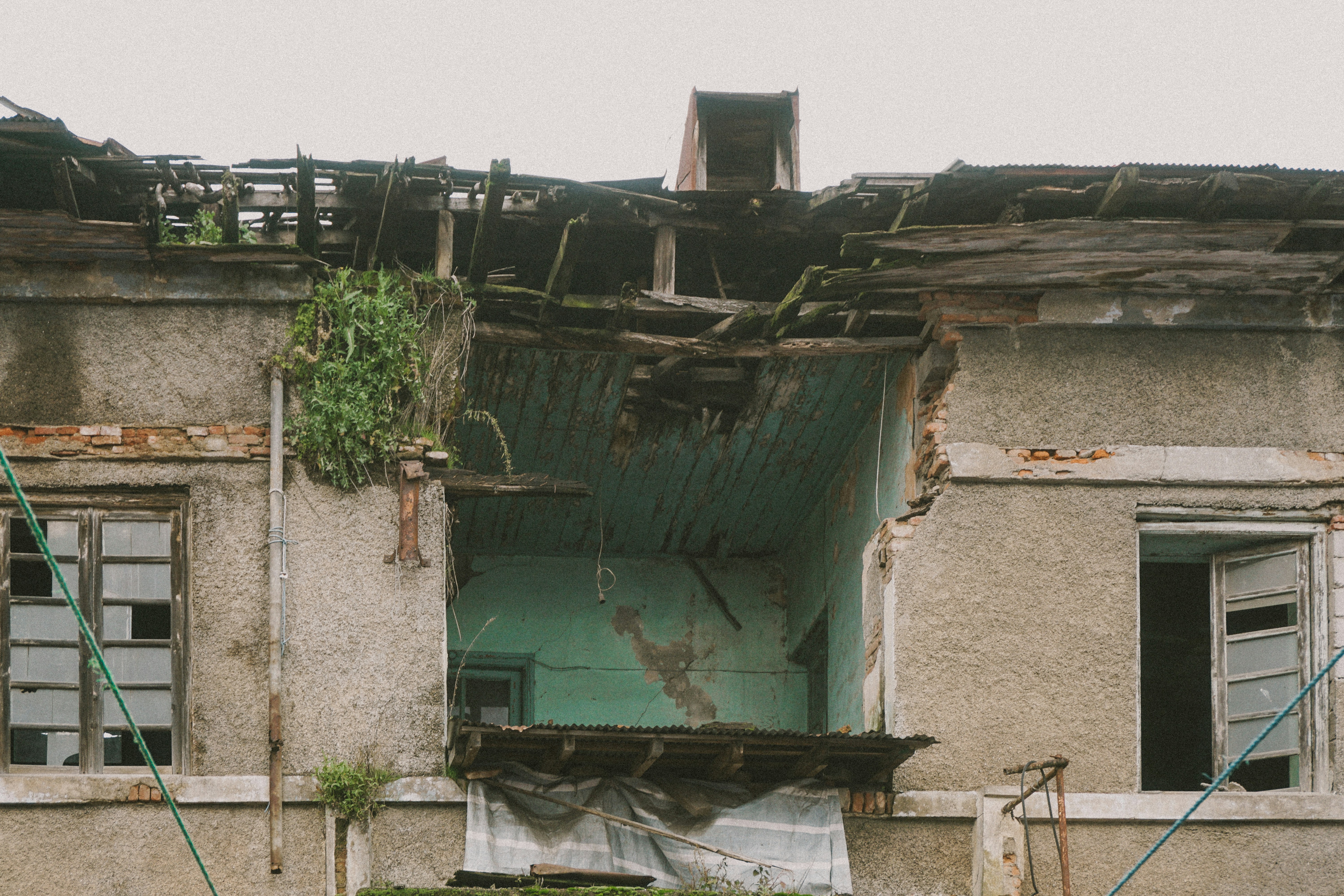 Ruins Above a Crumbling Terrace: Green Wall Behind Weathered Facade
