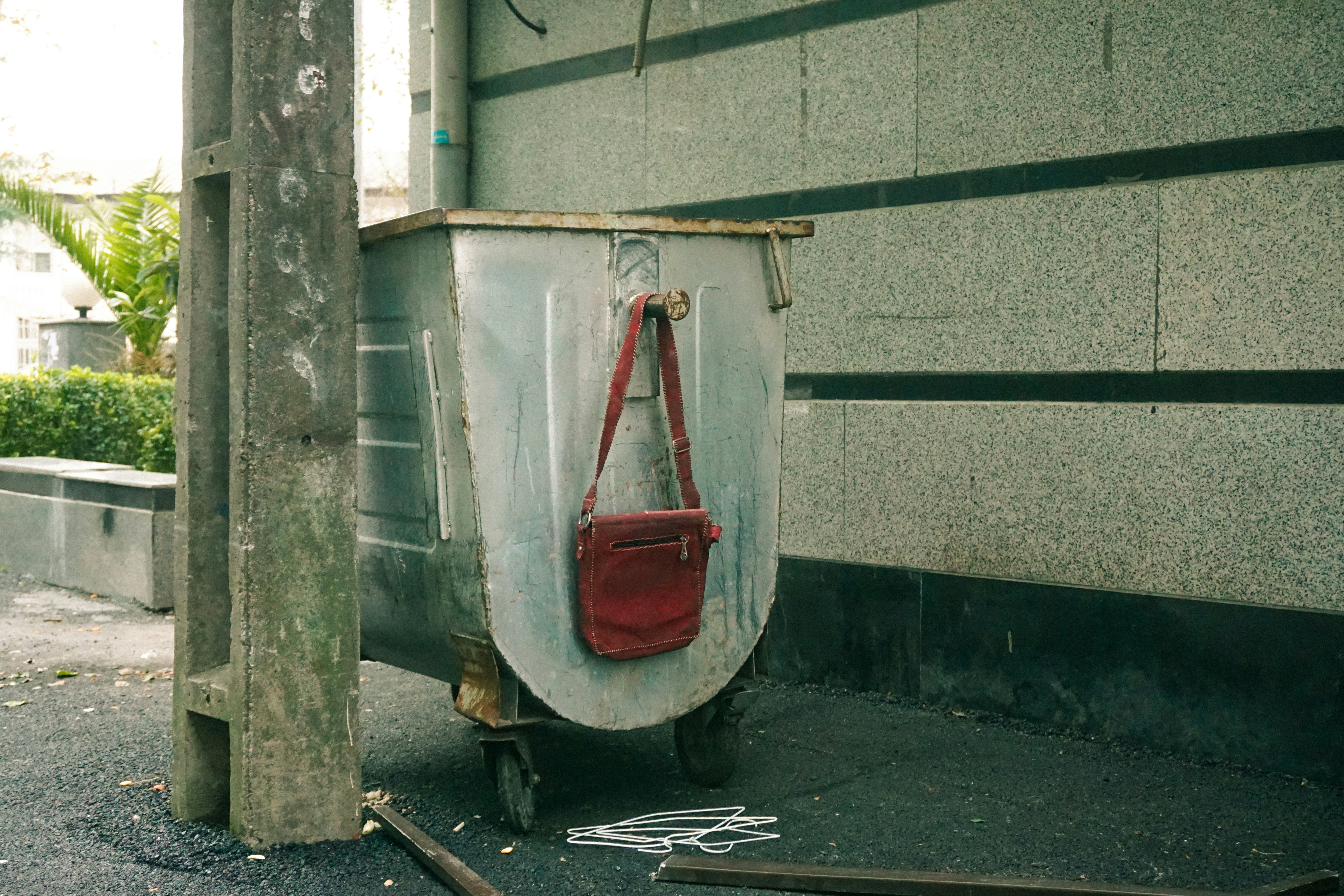 Urban Distant Wrench: A Red Bag Adrift on a Trash Cart