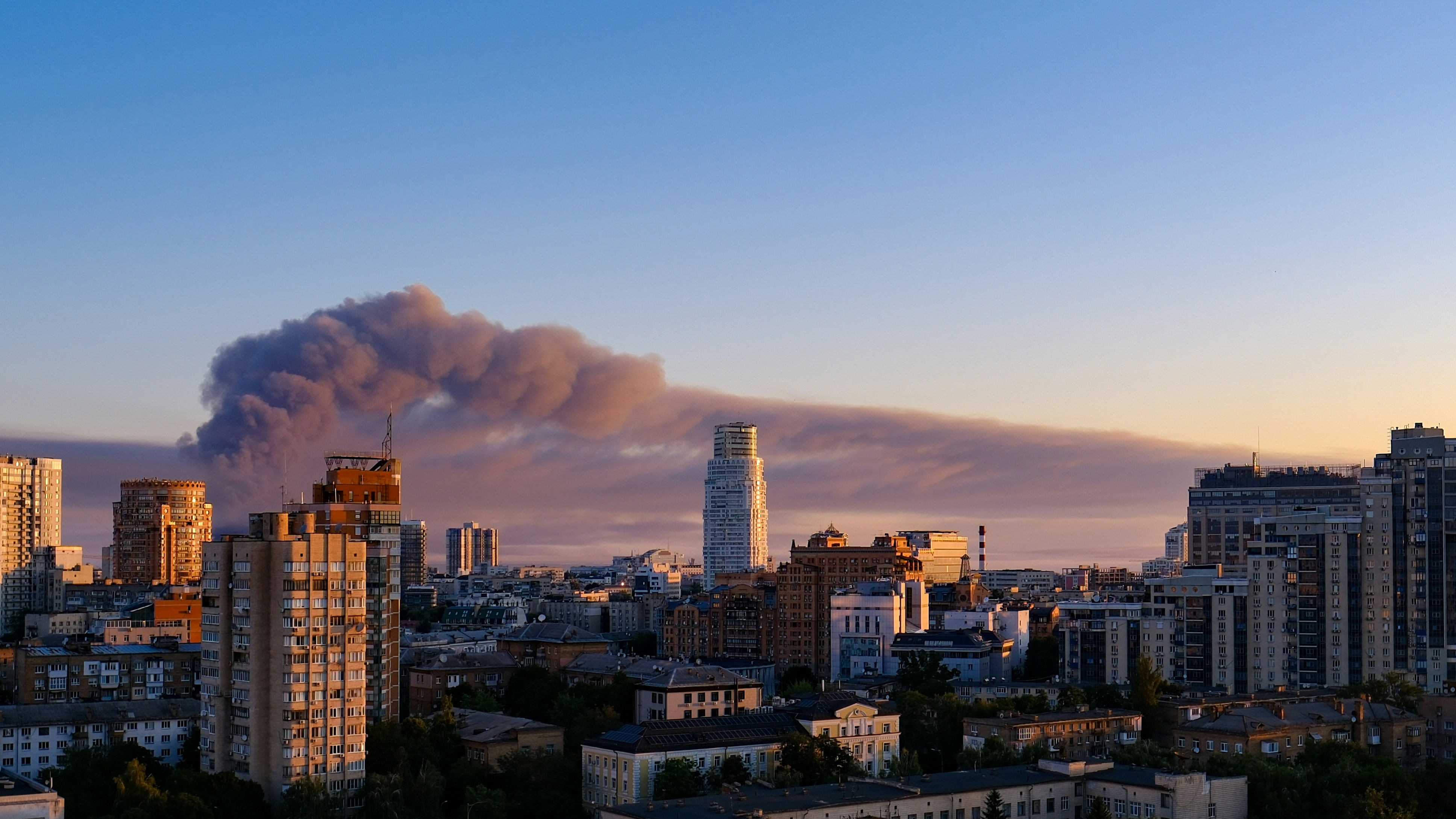 Smoke Over the Skyline: Evening Emergence Behind the High-Rise